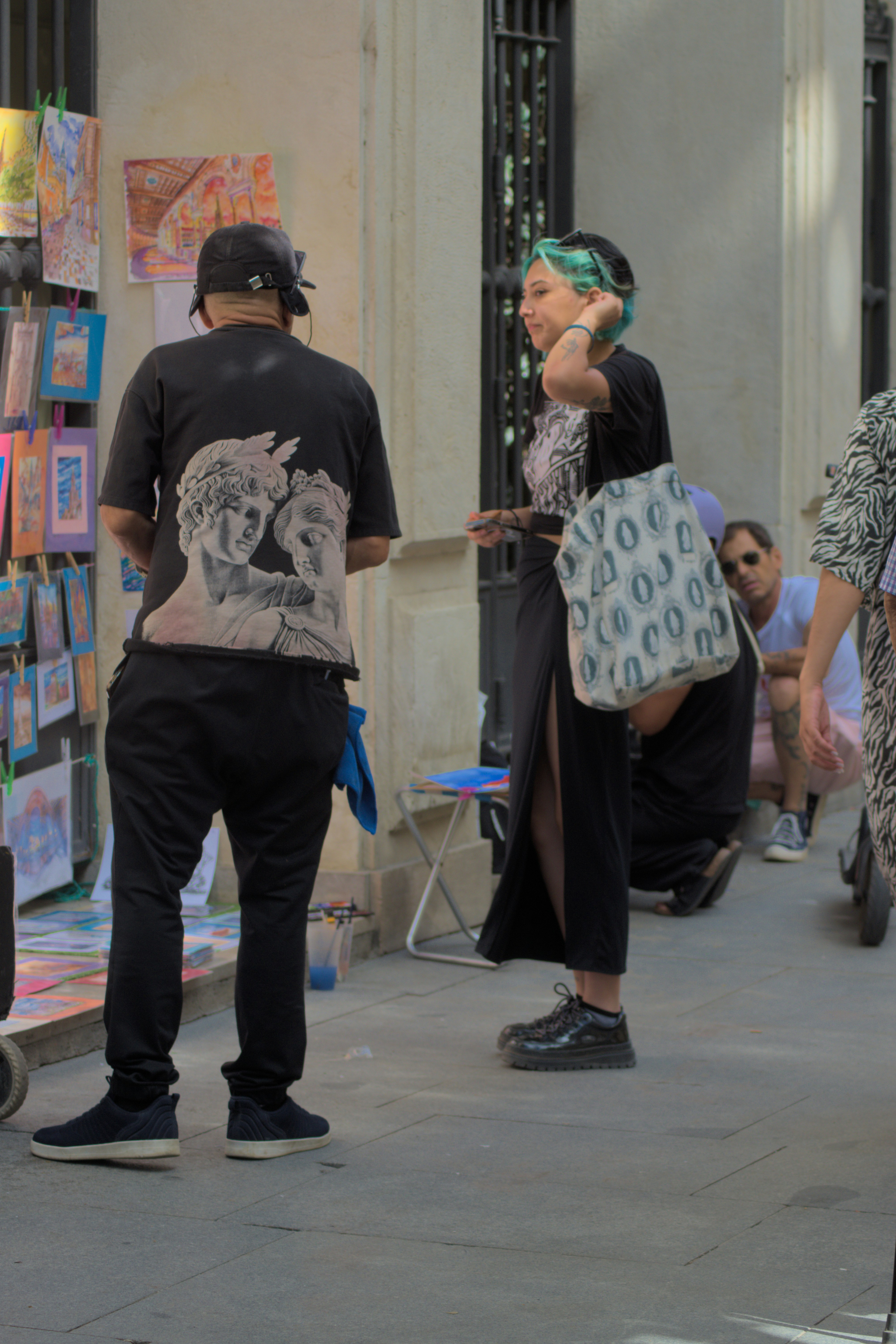 Two Street Artists in Conversation Among Colorful Sketches