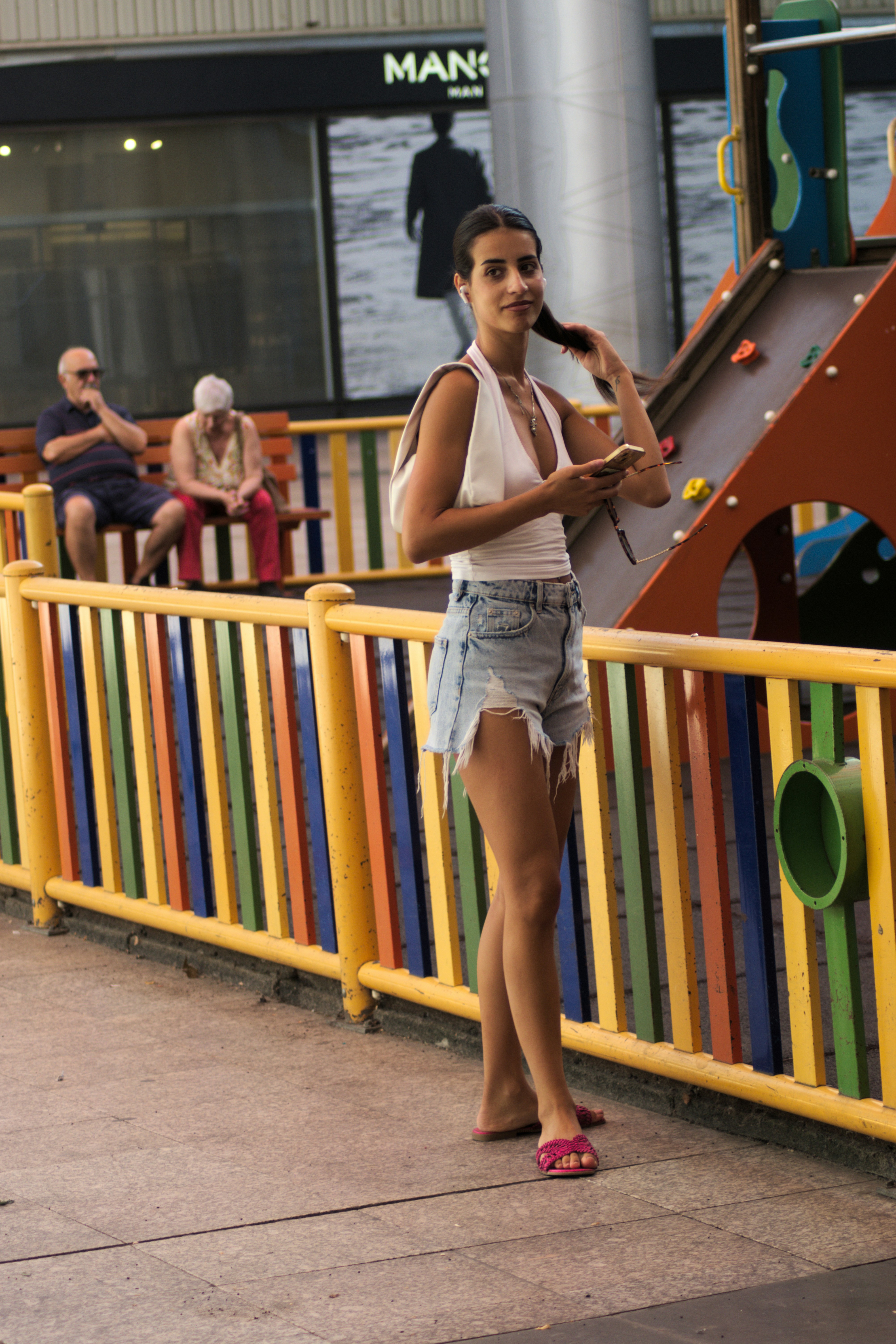 Sunlit Tourist Standing by a Colorful Railing