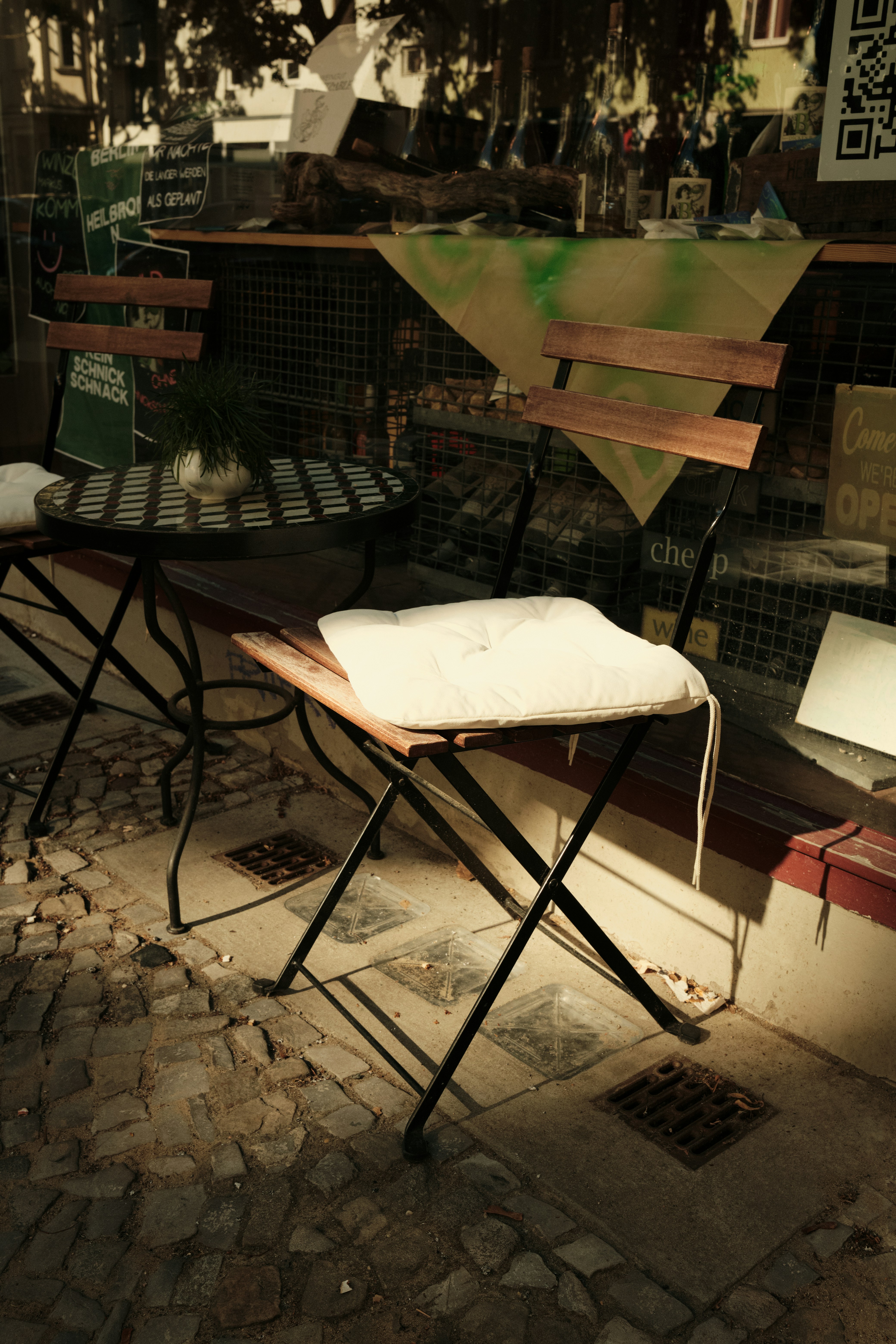 Sunlit Café Bench with Cushioned Seat in a European Alley