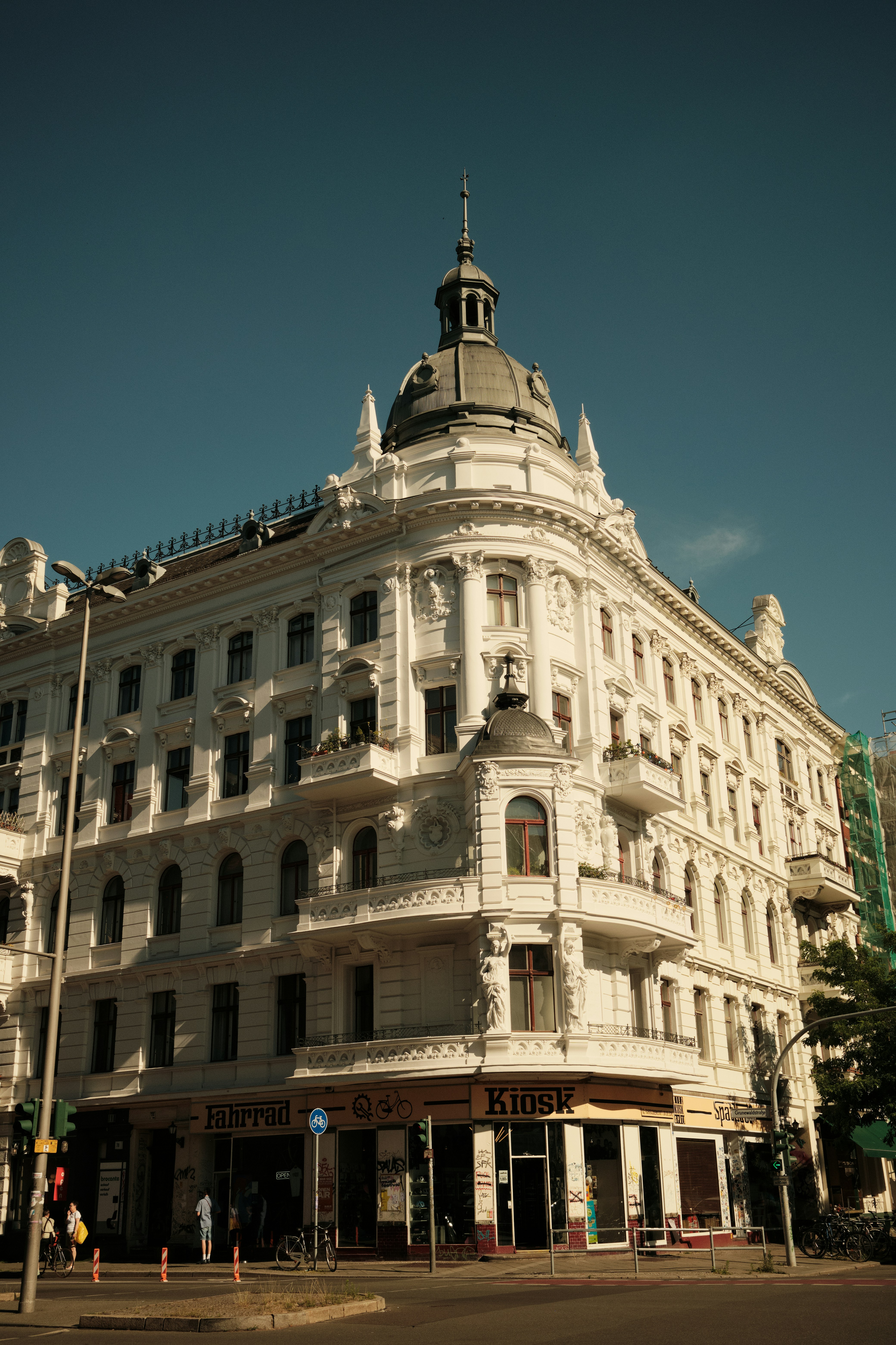 Ornate Corner: A Topped White Facade Rising Over a Busy Street