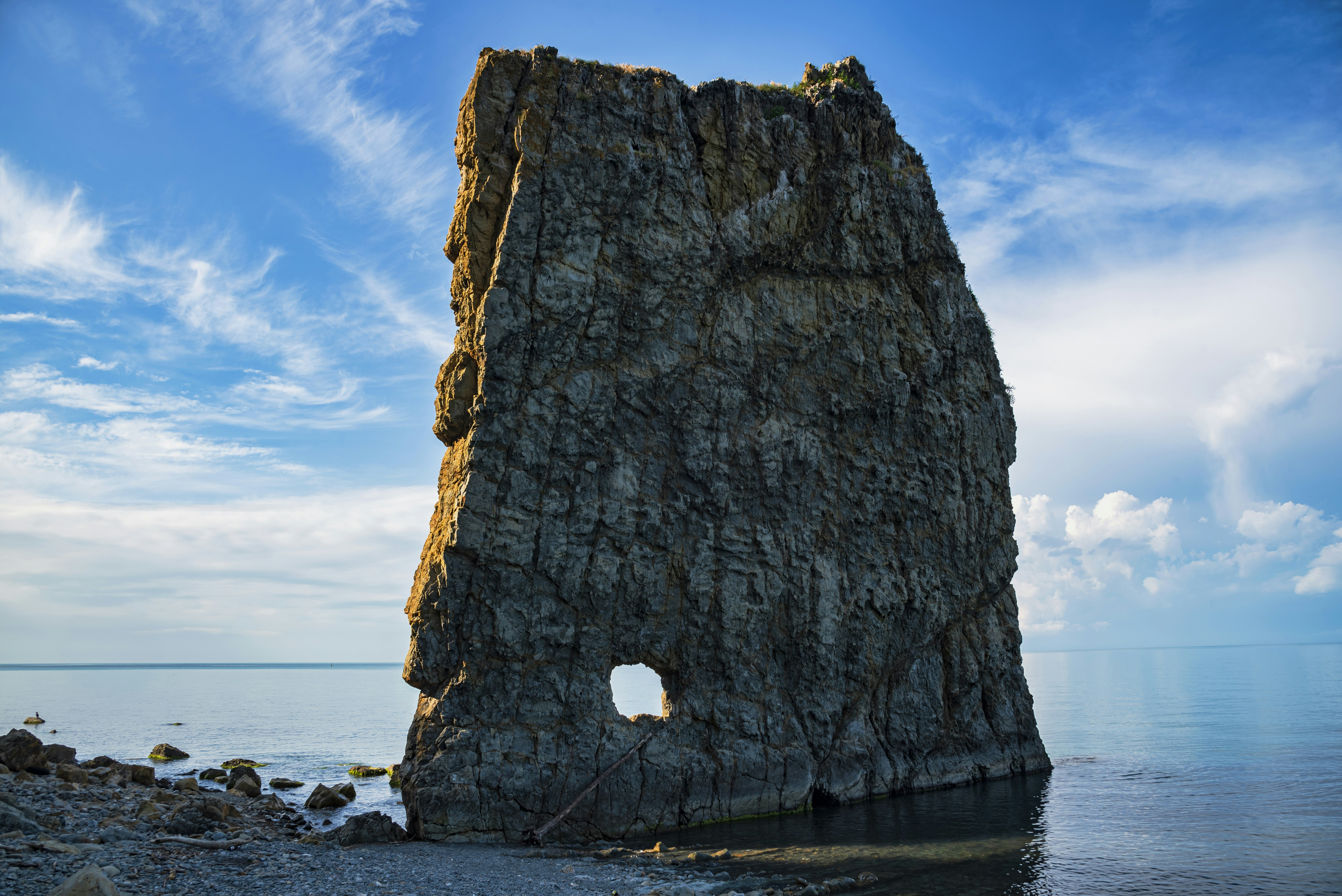 Sea Sentinel: A Stony Monolith Rising from Calm Waters