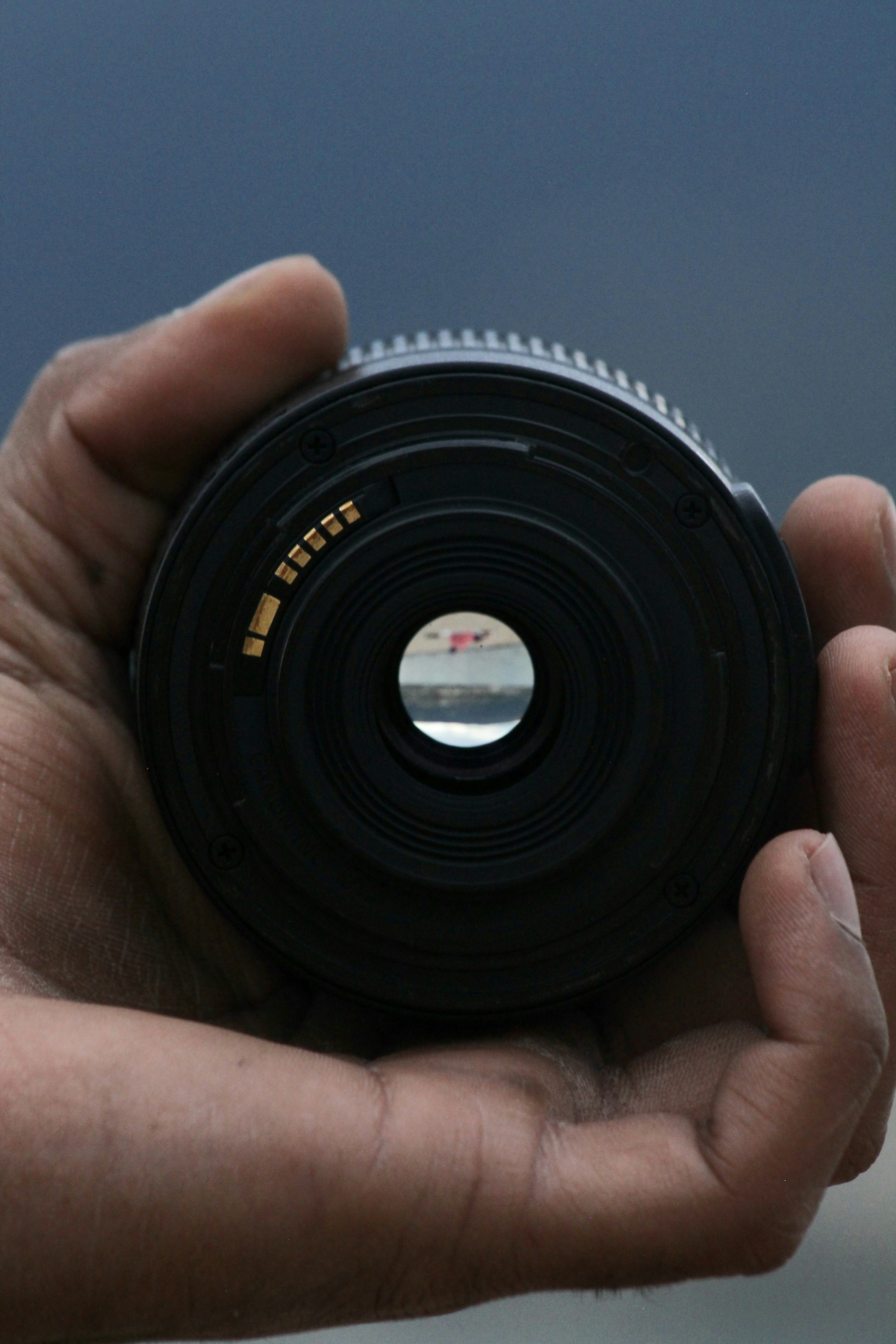 Centered View: Hands Grasping a Focused Lens with a Glimpse of the World