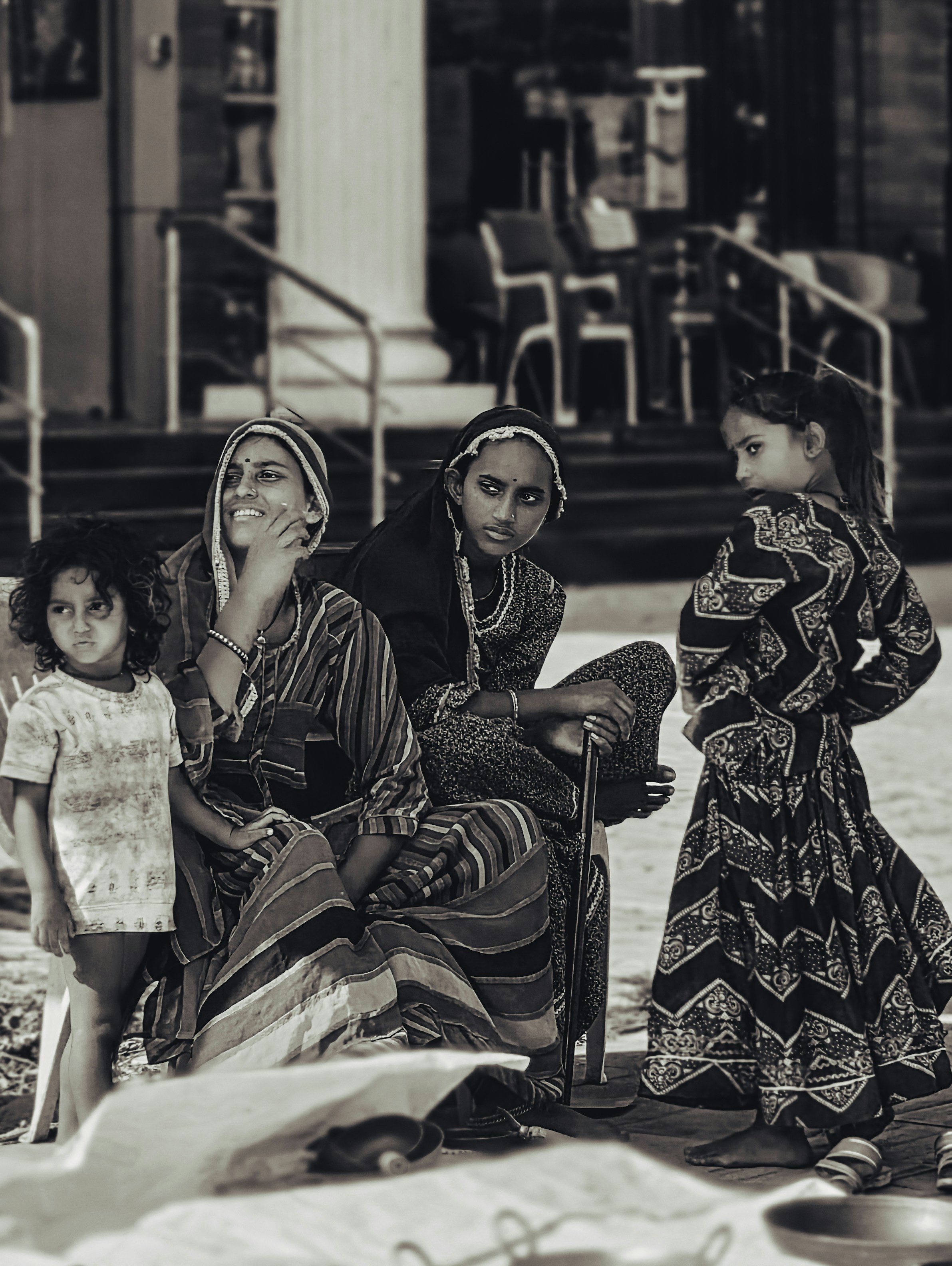 Sisters and a Child in Quiet Dialogue on a Bazaar Steps