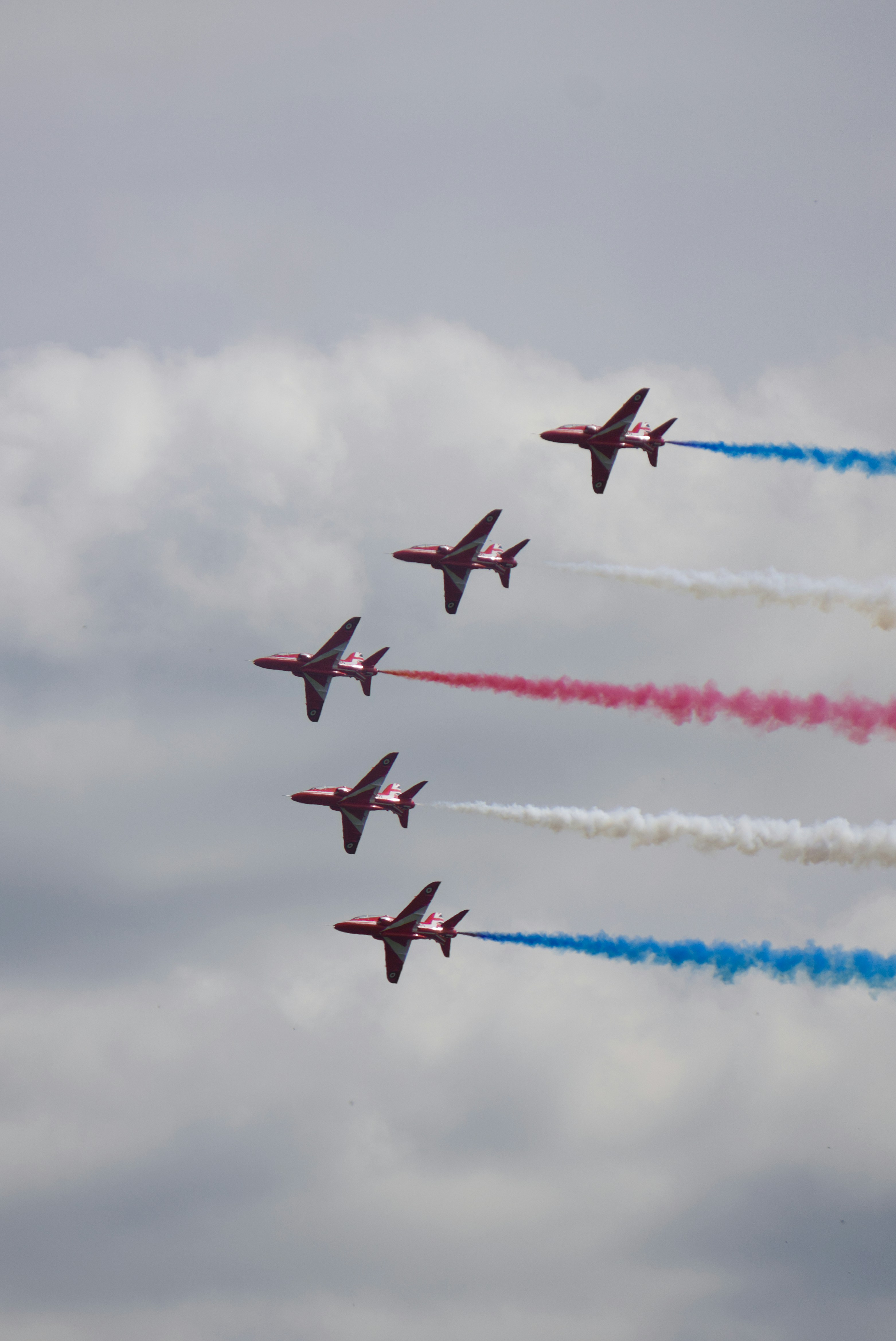Five Red Jets Trace Colorful Veins Across a Clouded Sky