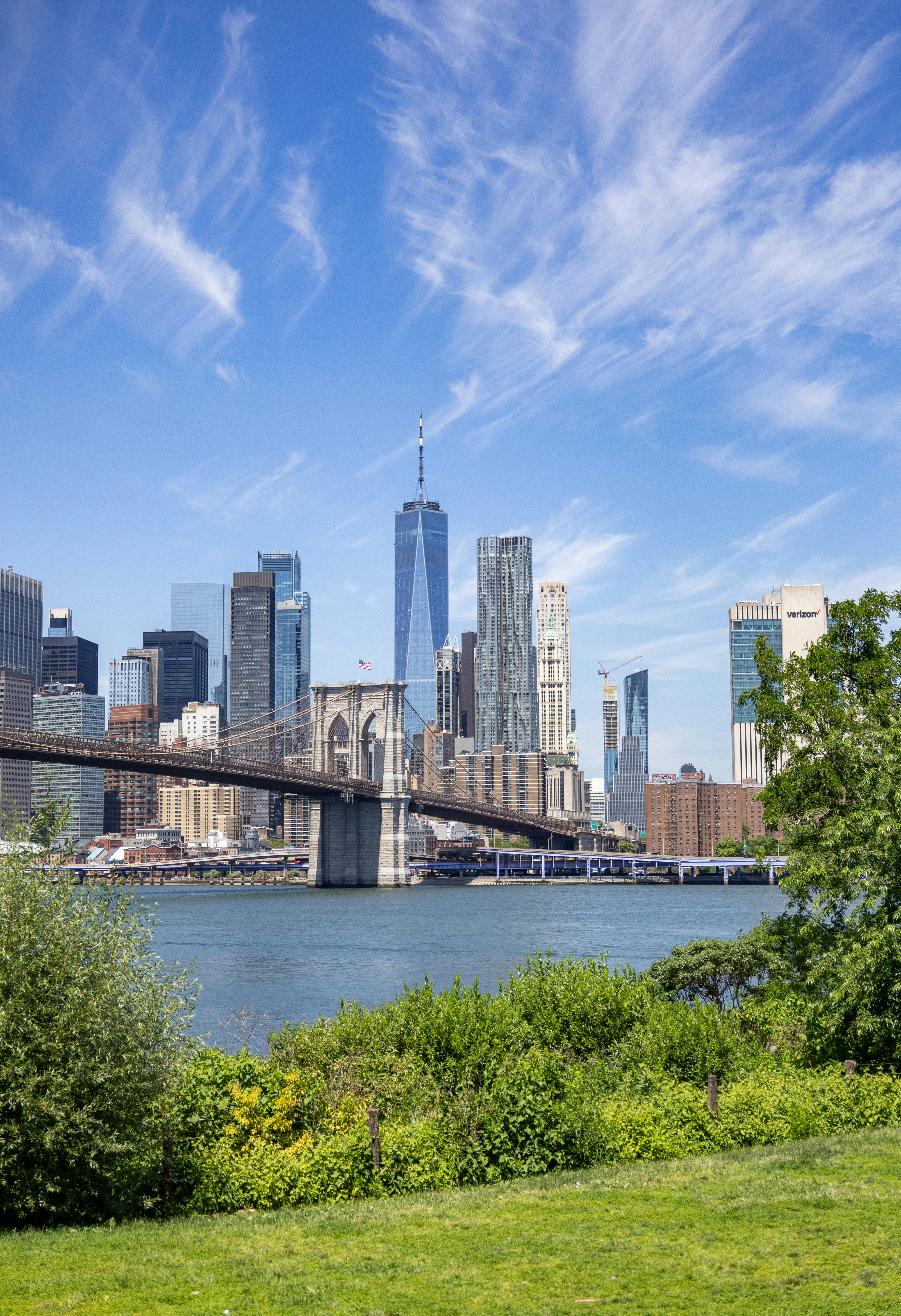 Sunlit Manhattan Skyline Over the East River with Brooklyn Bridge