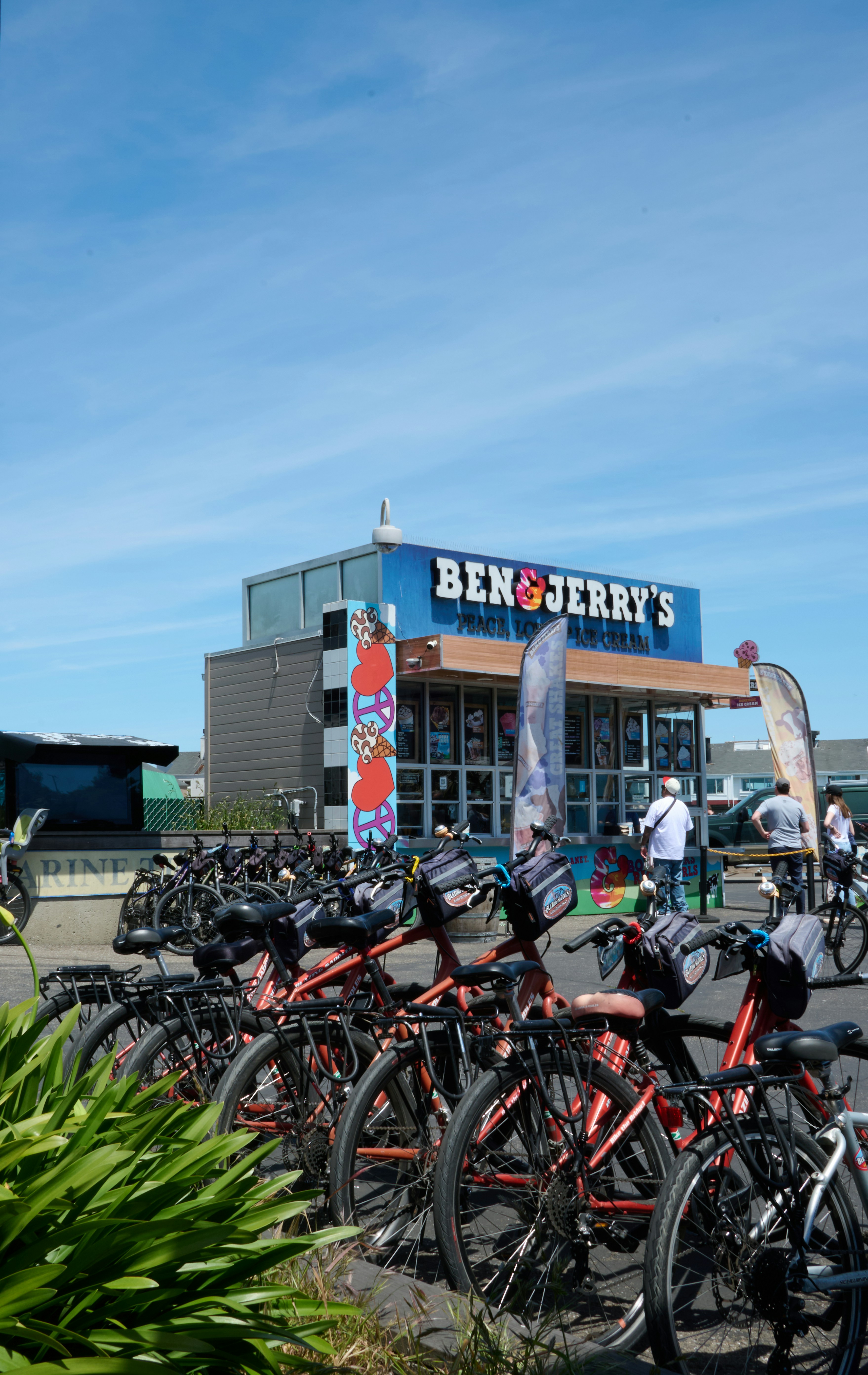 Bicycles parked outside a ben & jerry's ice cream shop.