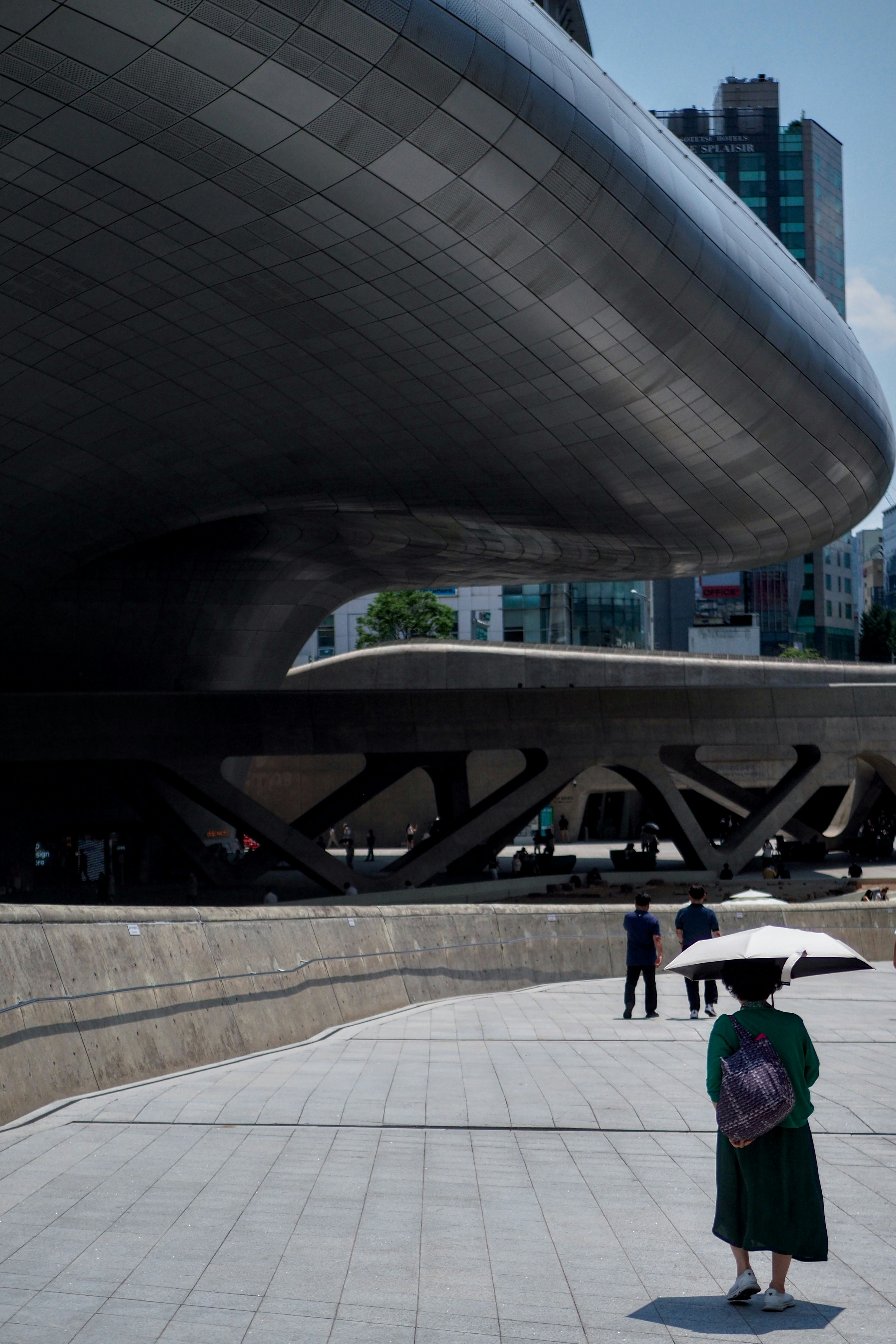 Curved Metal Monolith Over a Quiet Plaza