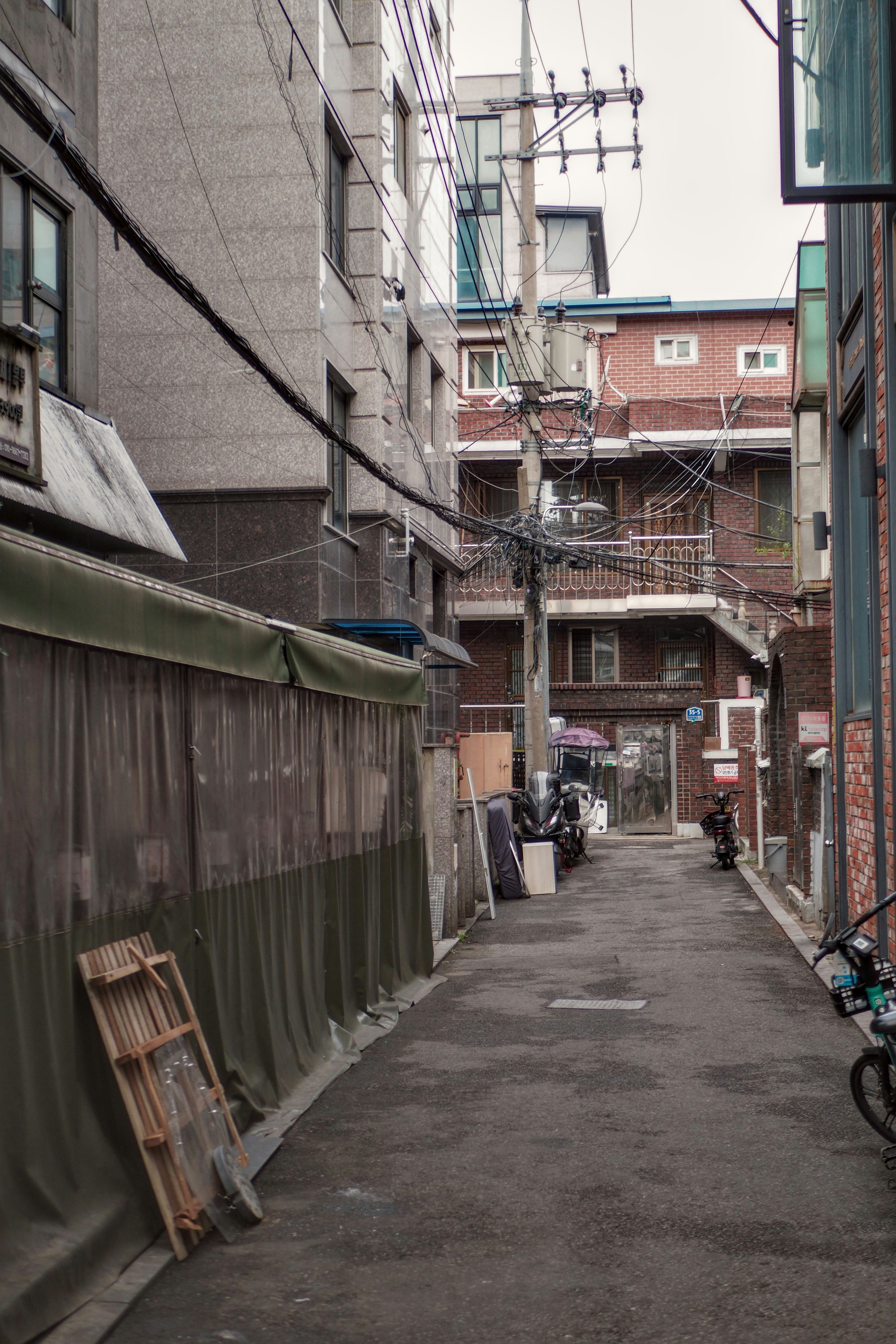 Urban Alleyway Corridor with Overhead Wiring and Hidden Motorbikes