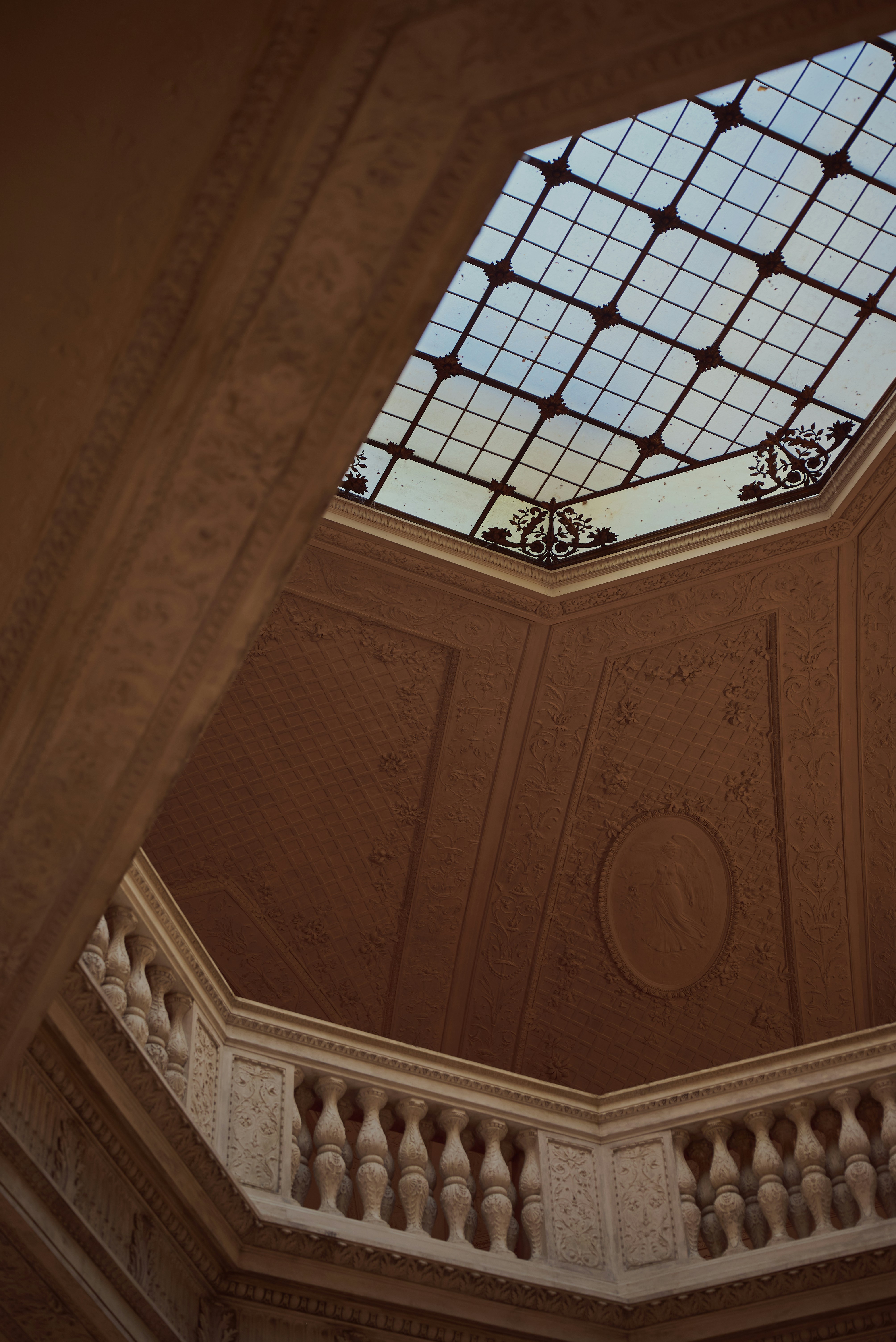 Architectural Echoes: Sunlit Glass and Carved Plaster in a Historic Atrium