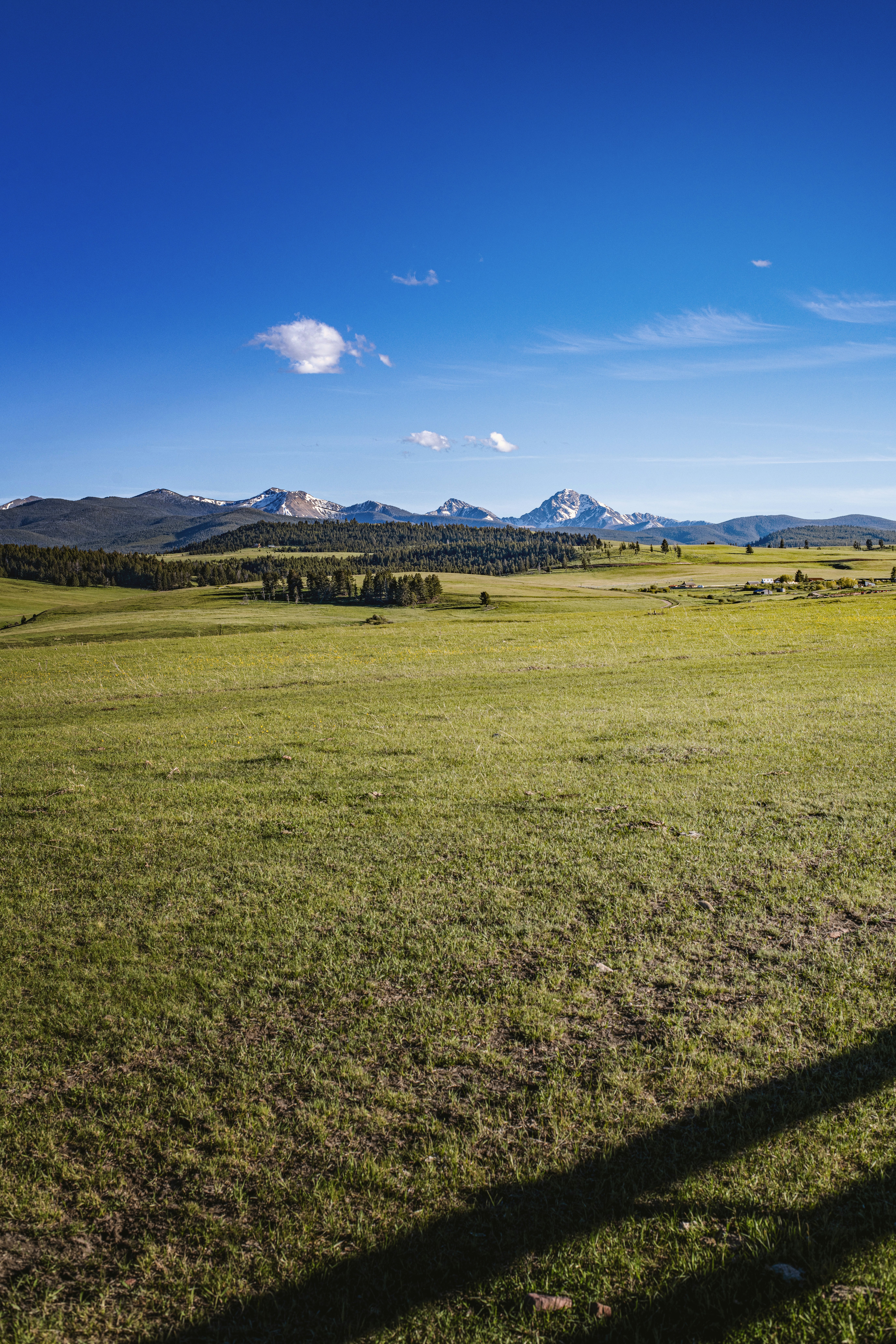 Floating Sky Over Rolling Fields and Snow-Capped Peaks