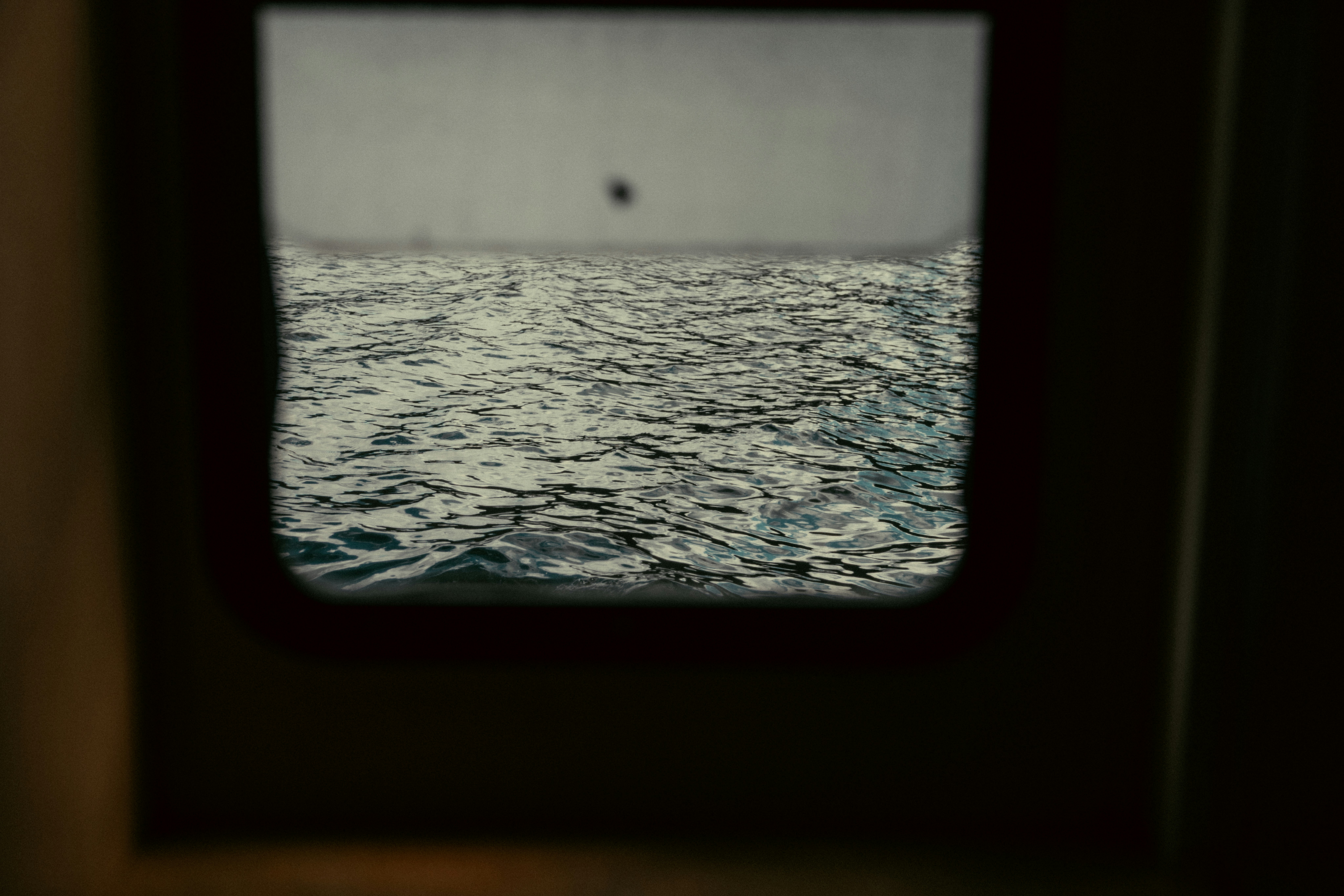 Sea Window: Light on the Horizon Through a Porthole