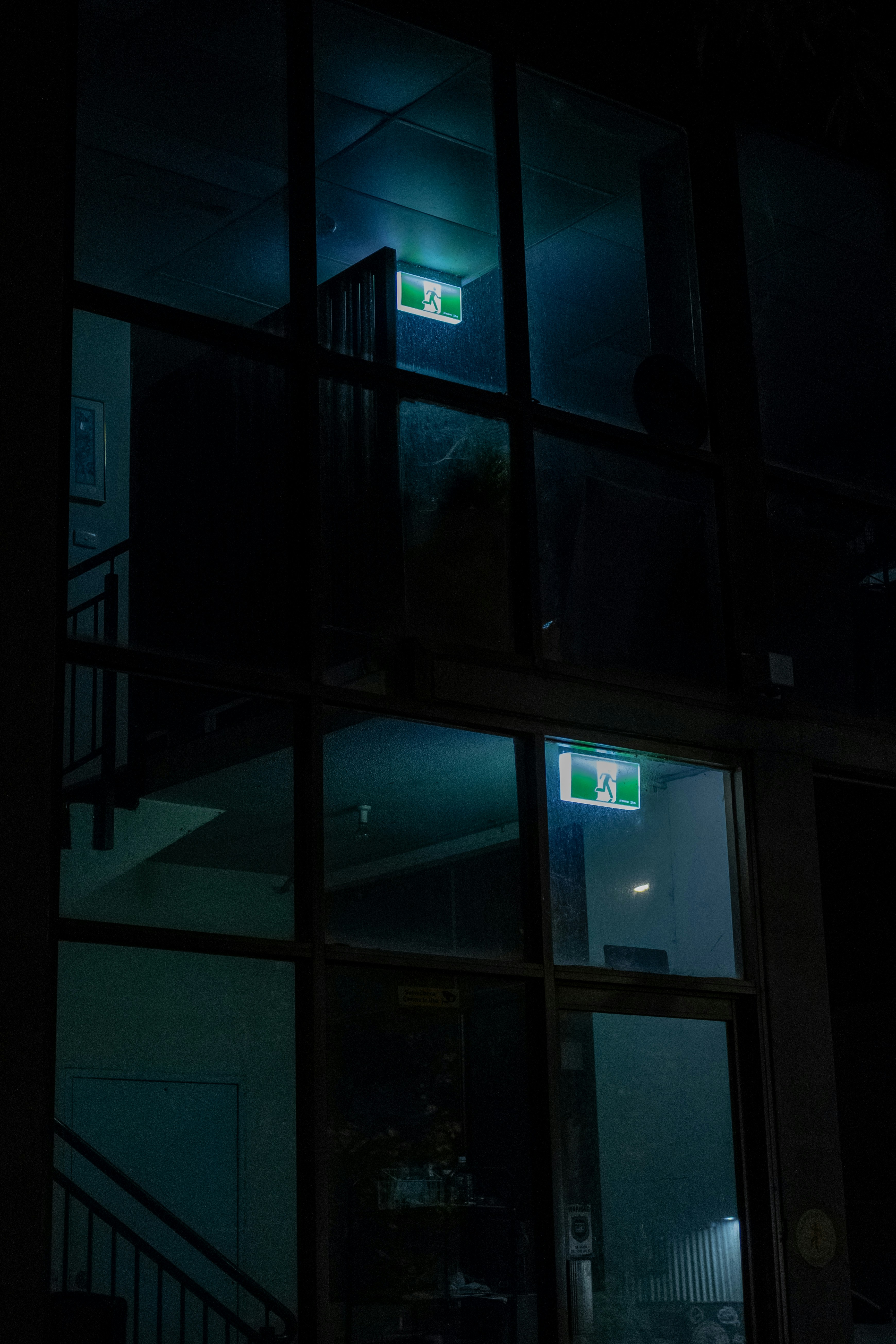 Emerald Exit: Quiet Night at the Glass-Faced Stairwell