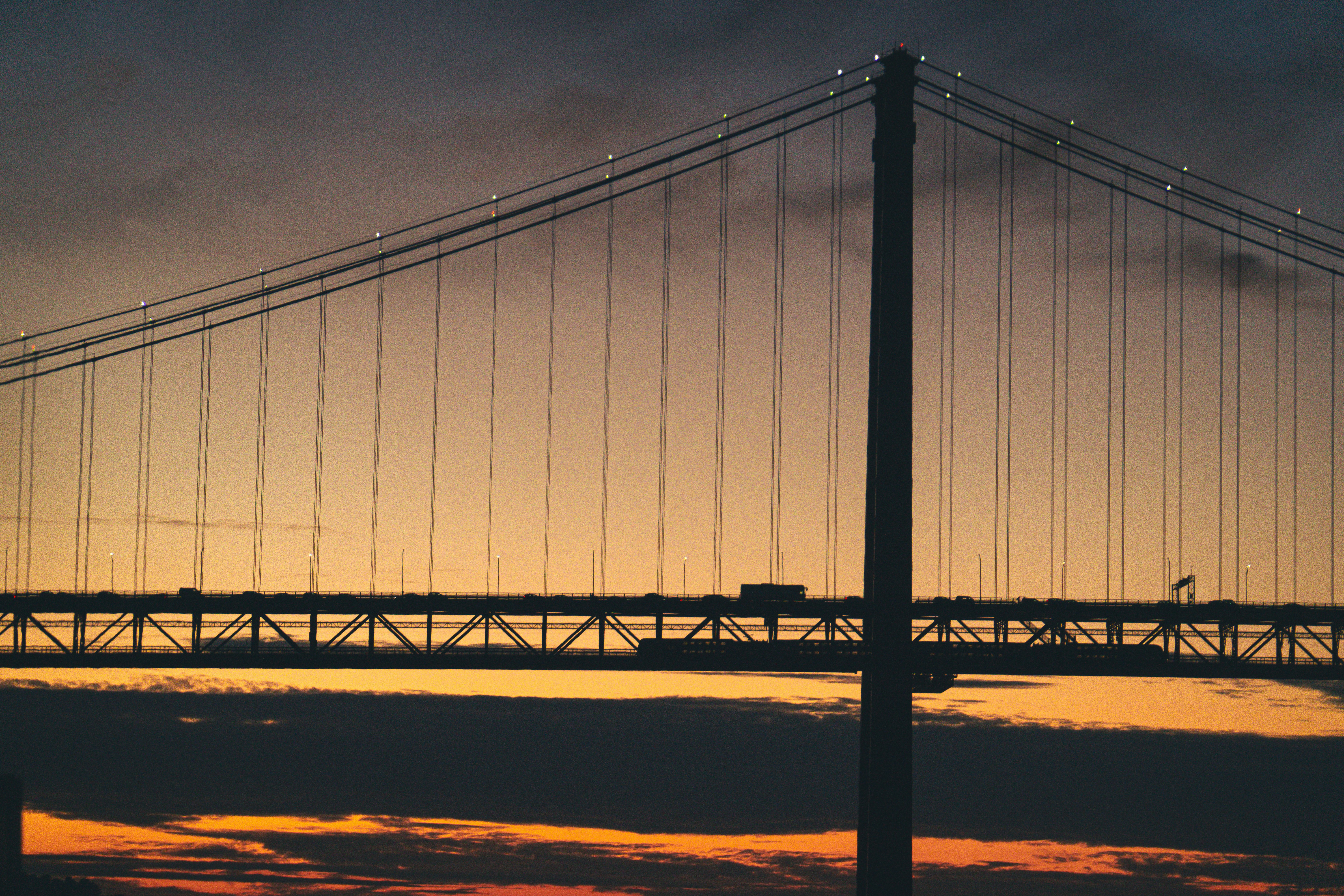 Rising Span at Dusk: A Bridge Silhouette Over Quiet Waters