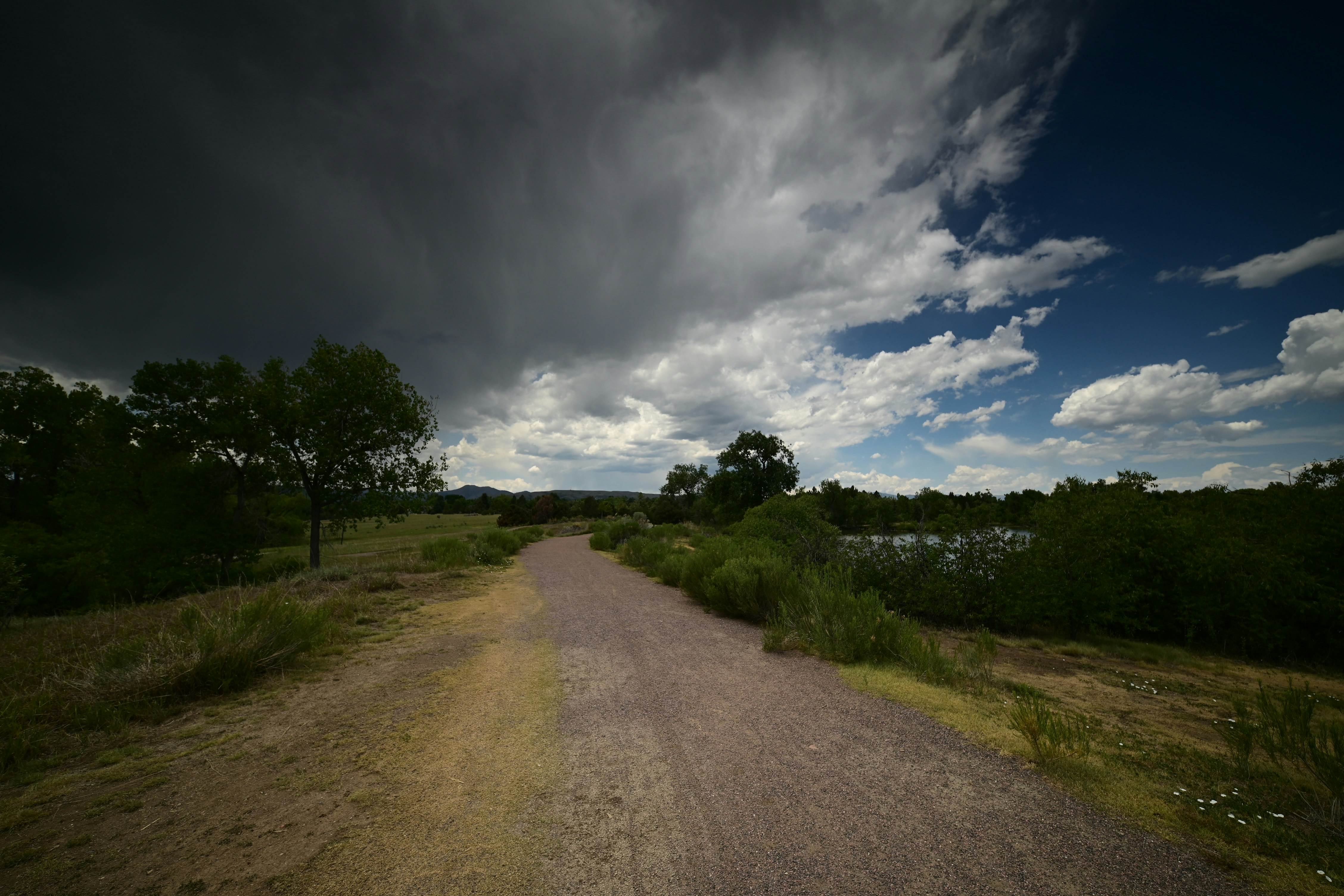 Storm-Quiet Trail: A Lone Path Under Expanding Clouds
