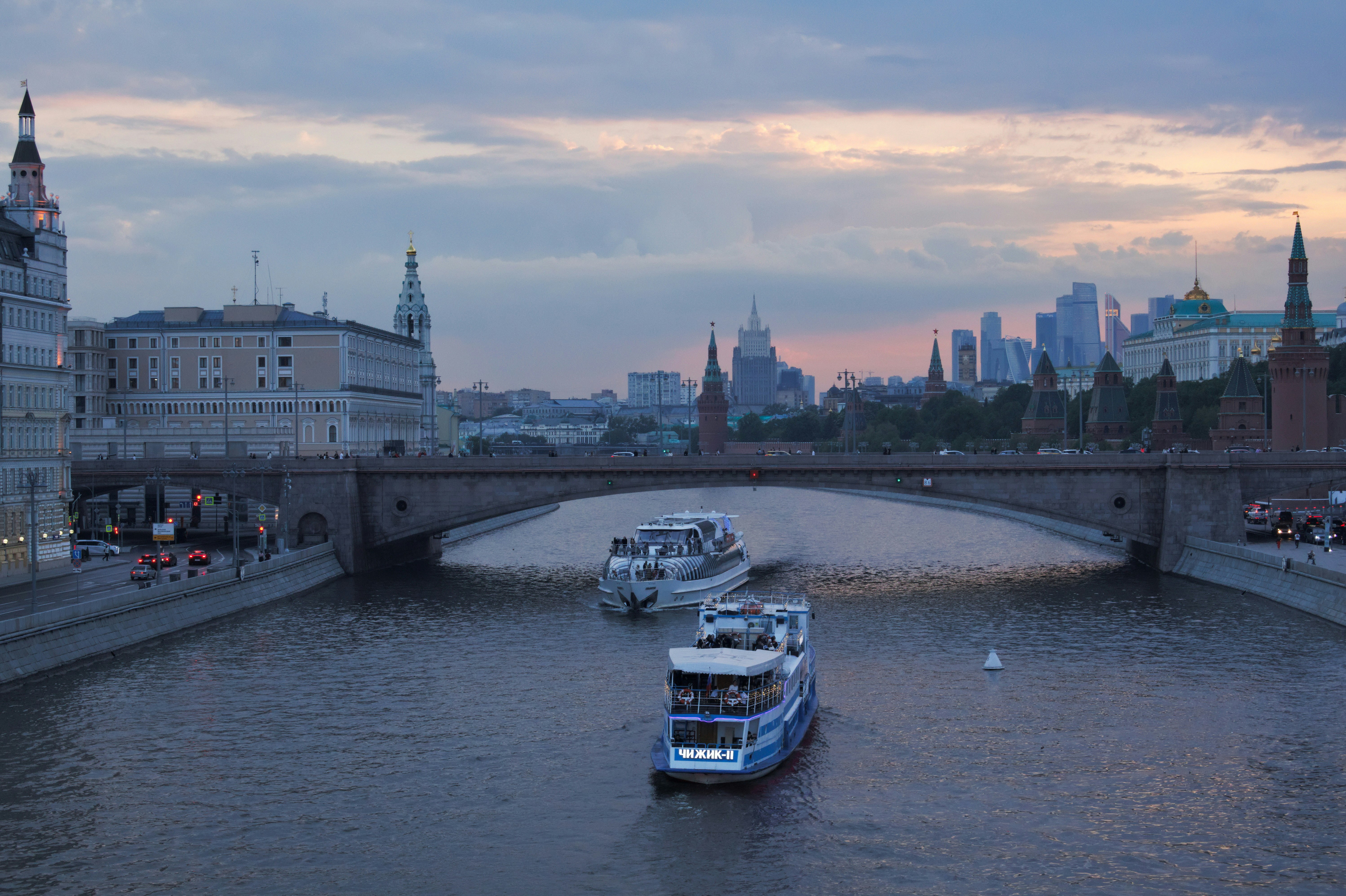 River Arches at Dusk: Boats under Kremlin-Style Skyline