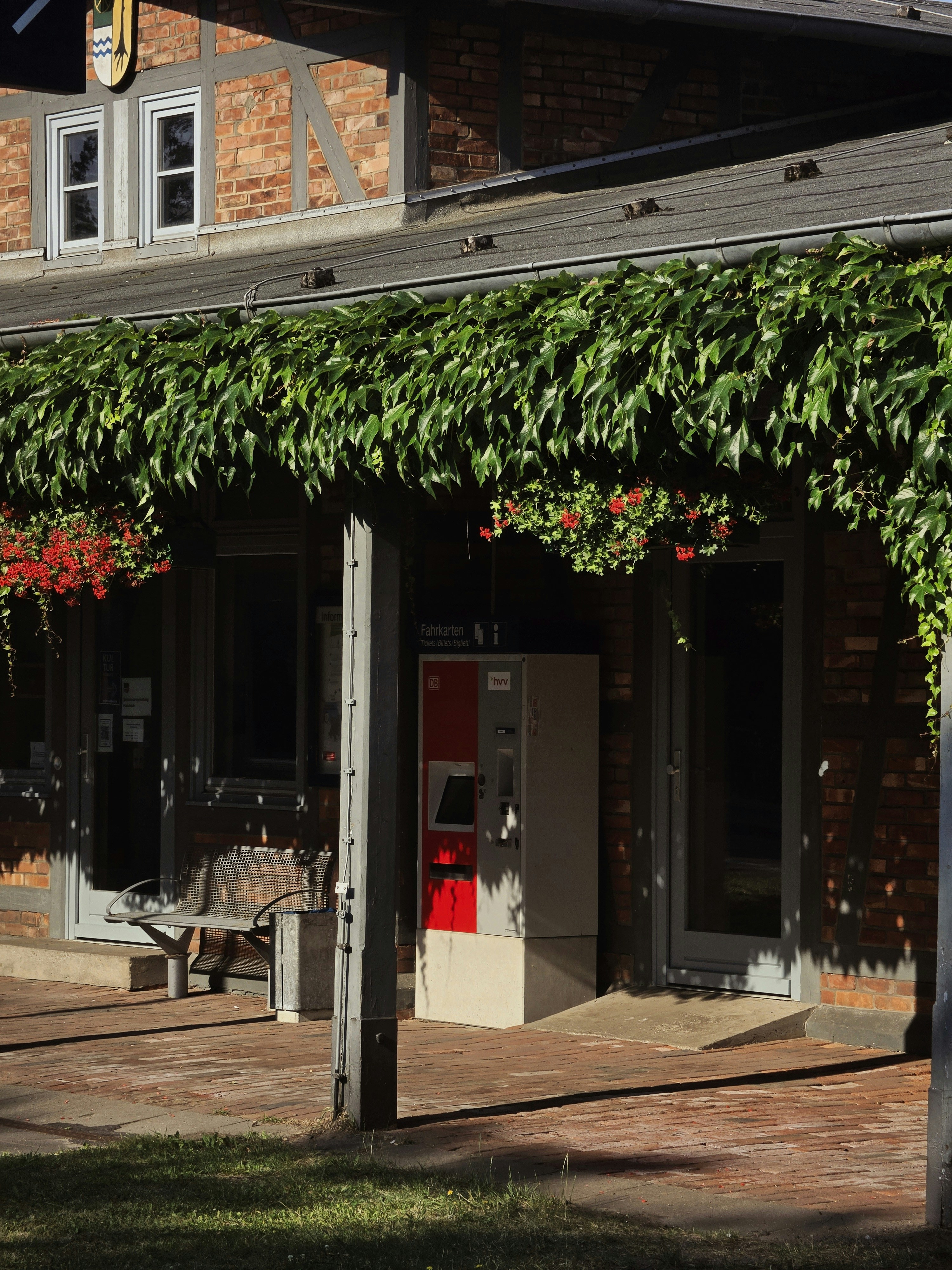Brick Facade and Vines: A Quiet Shopfront with Red ATM