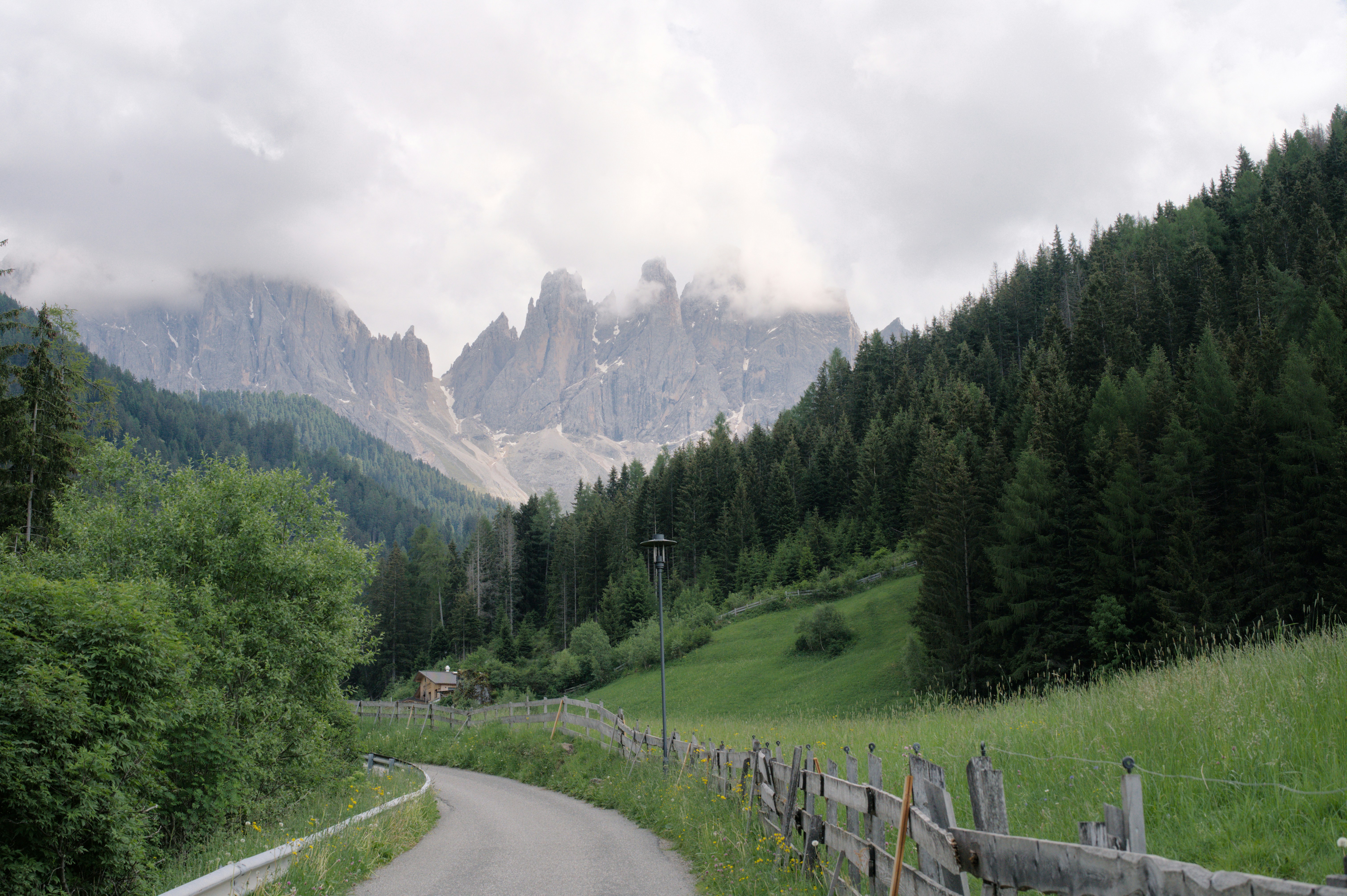 Trail to the Peaks: A Quiet Alpine Road Under Cloudy Skies