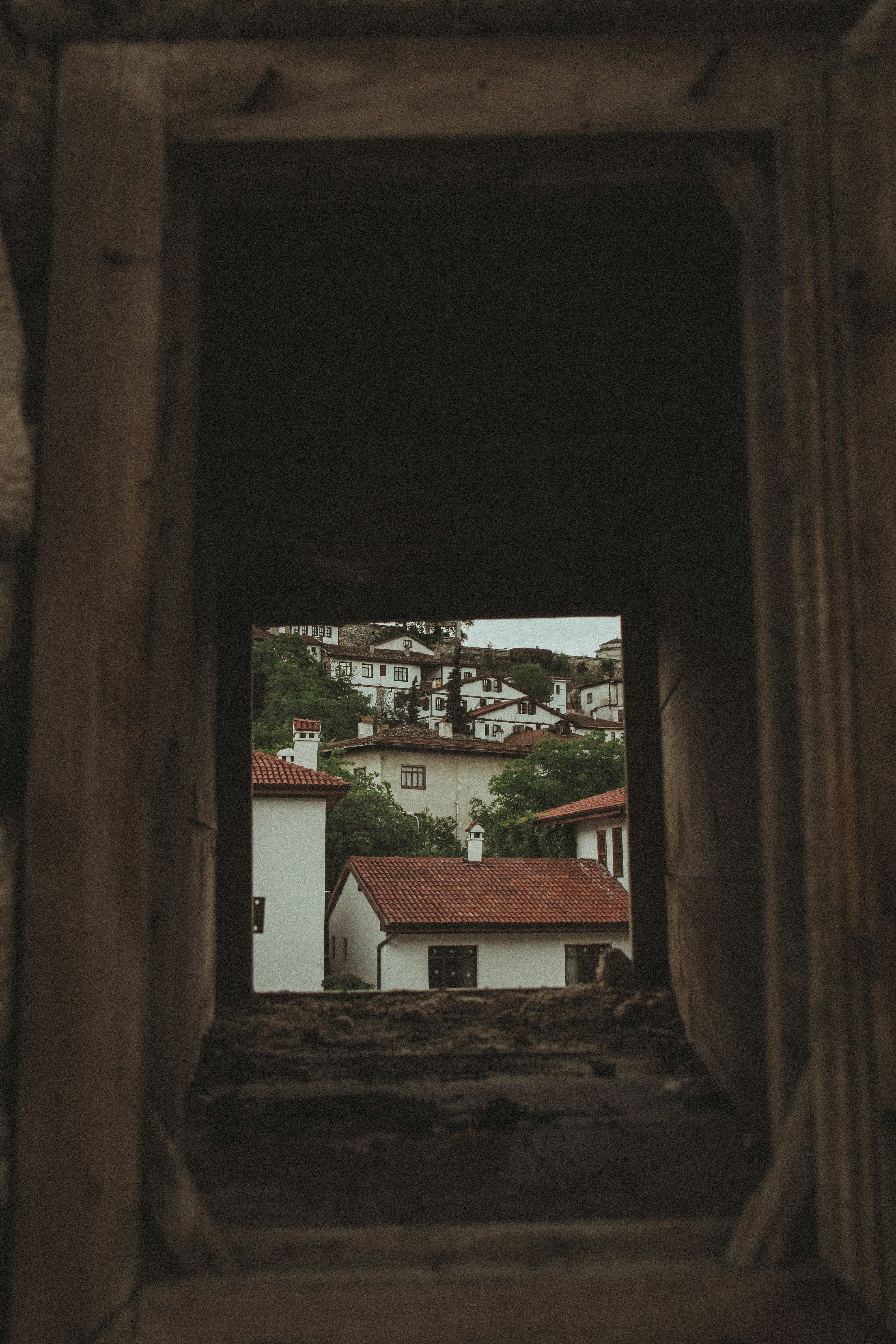 Through the Frame: Quiet Village Beyond a Stony Corridor