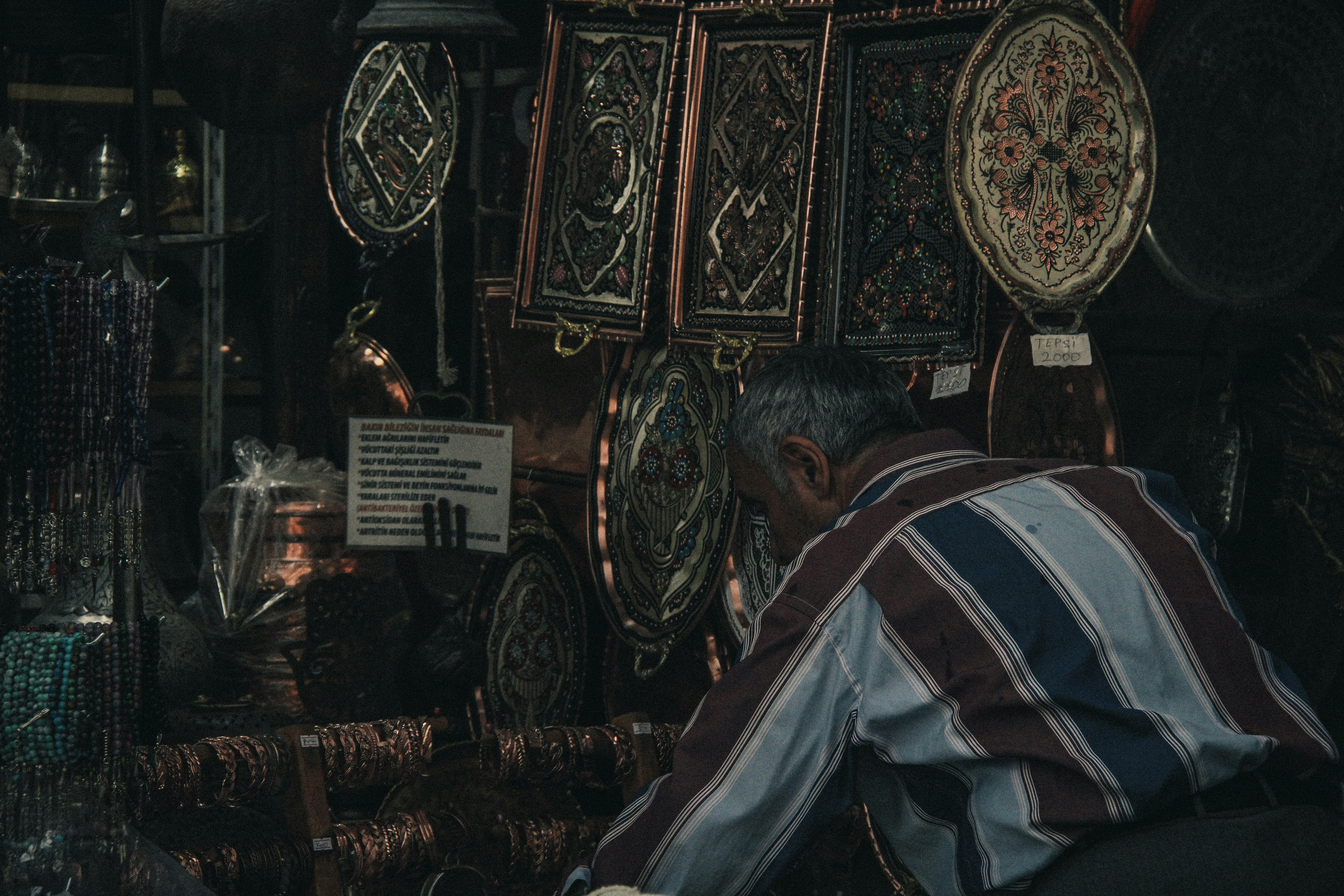 Market Stall Portrait: Hands at Work Beneath Ornate Textiles
