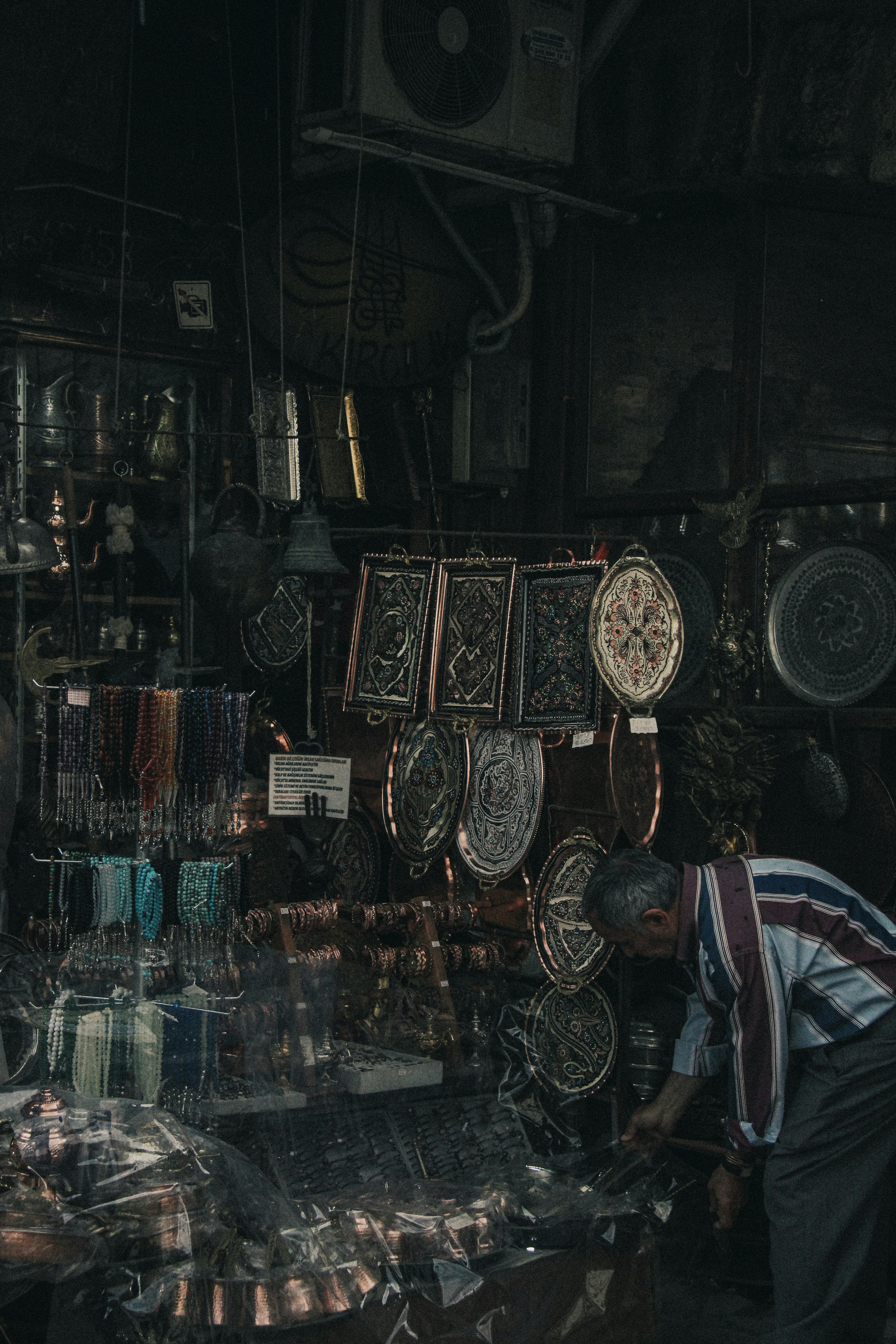 A Quiet Corner of Craft: Woven Rugs and Jewelry in a Dim Bazaar