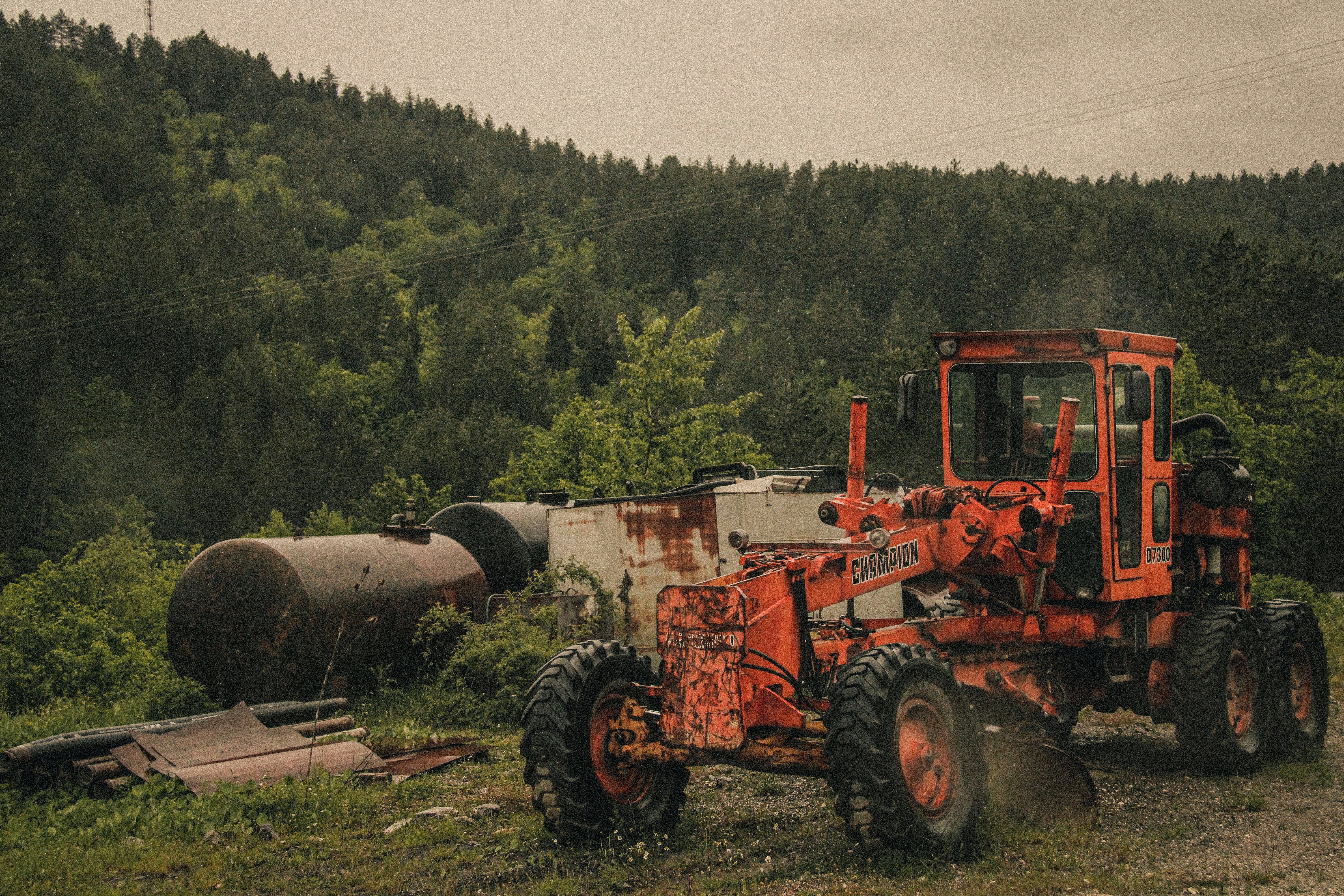 Weathered Firefighter: Red Tractor Reclines Among Echoing Pines