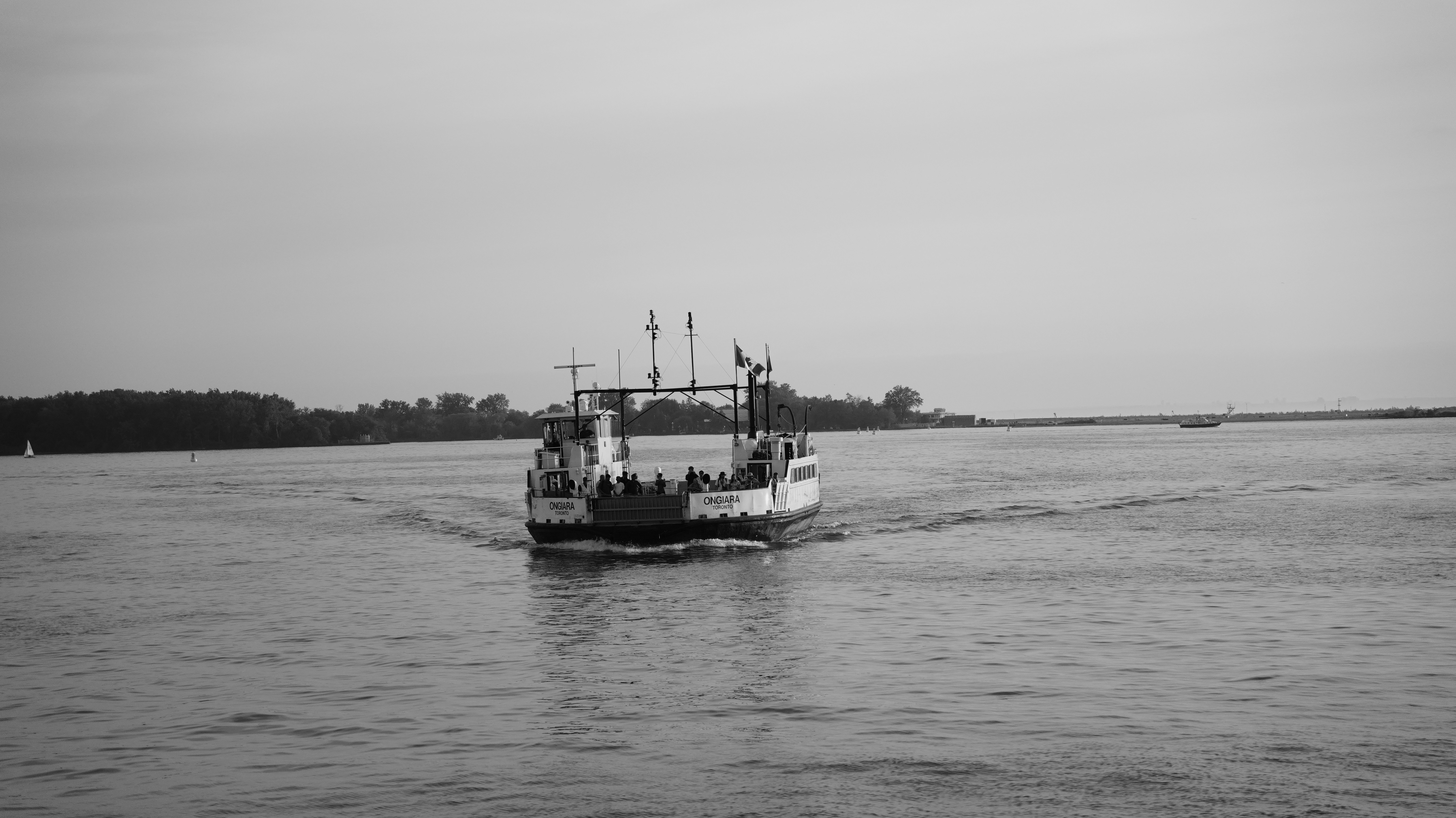 Toward the Horizon: A Quiet River Ferry Sails Under Gray Skies