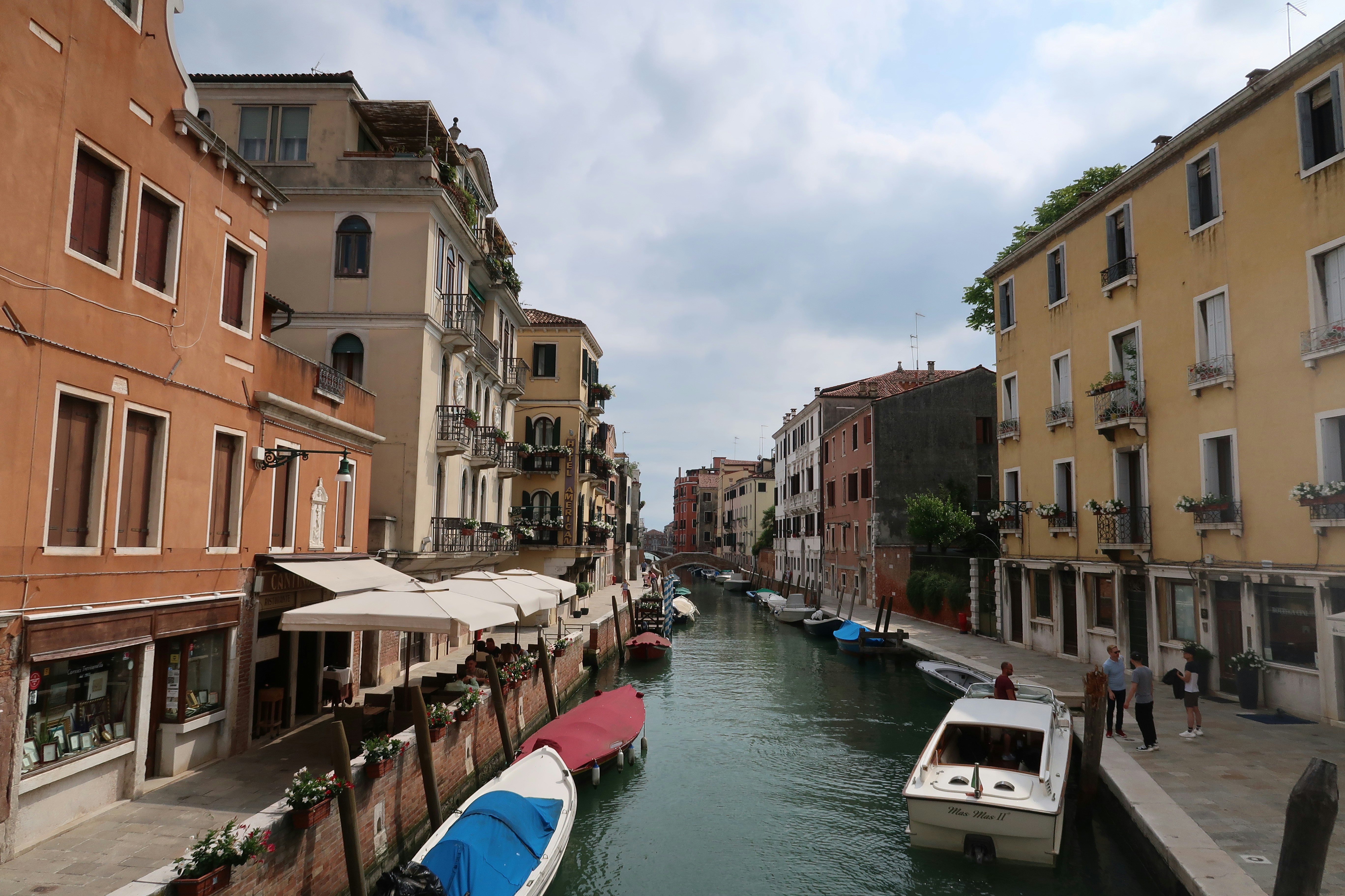 Canalfront in a Venetian Town: Boats, Colorwashed Facades, and a Busy Promenade
