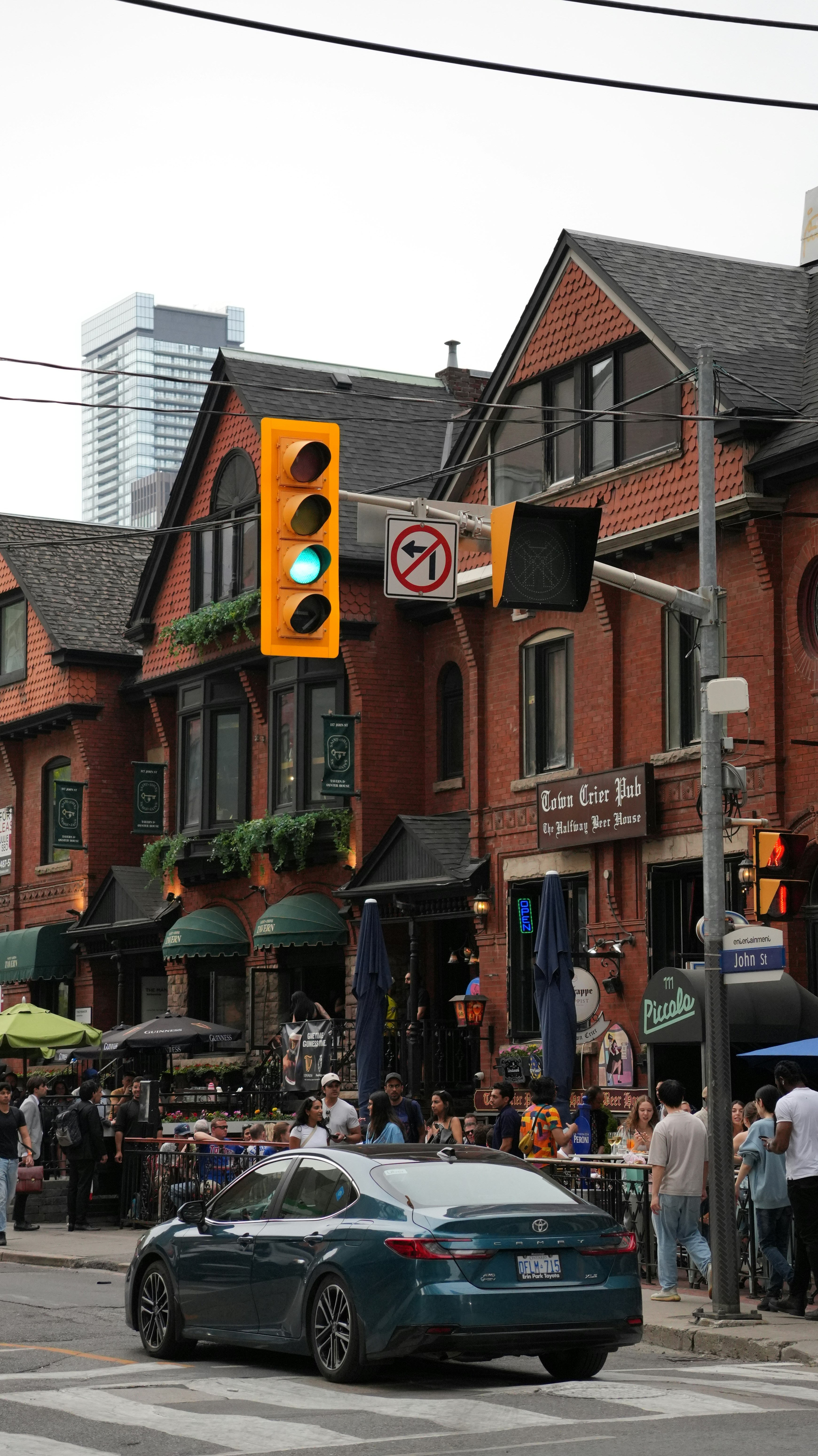 City Corner: Red Brick Pub, Neon Yellow Traffic Light, and a Motion of People
