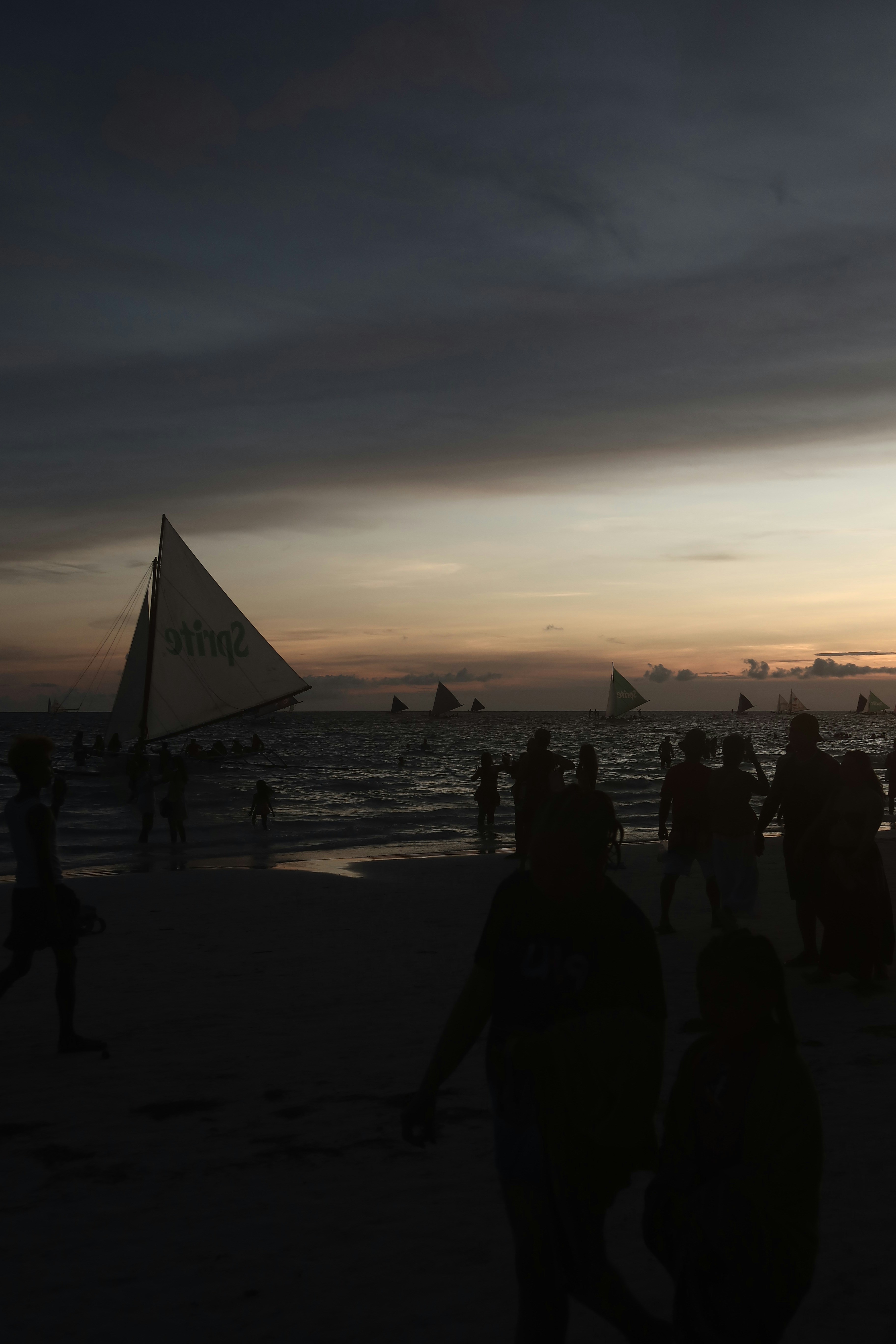 Sunset Sails: A Quiet Crowd at the Shore