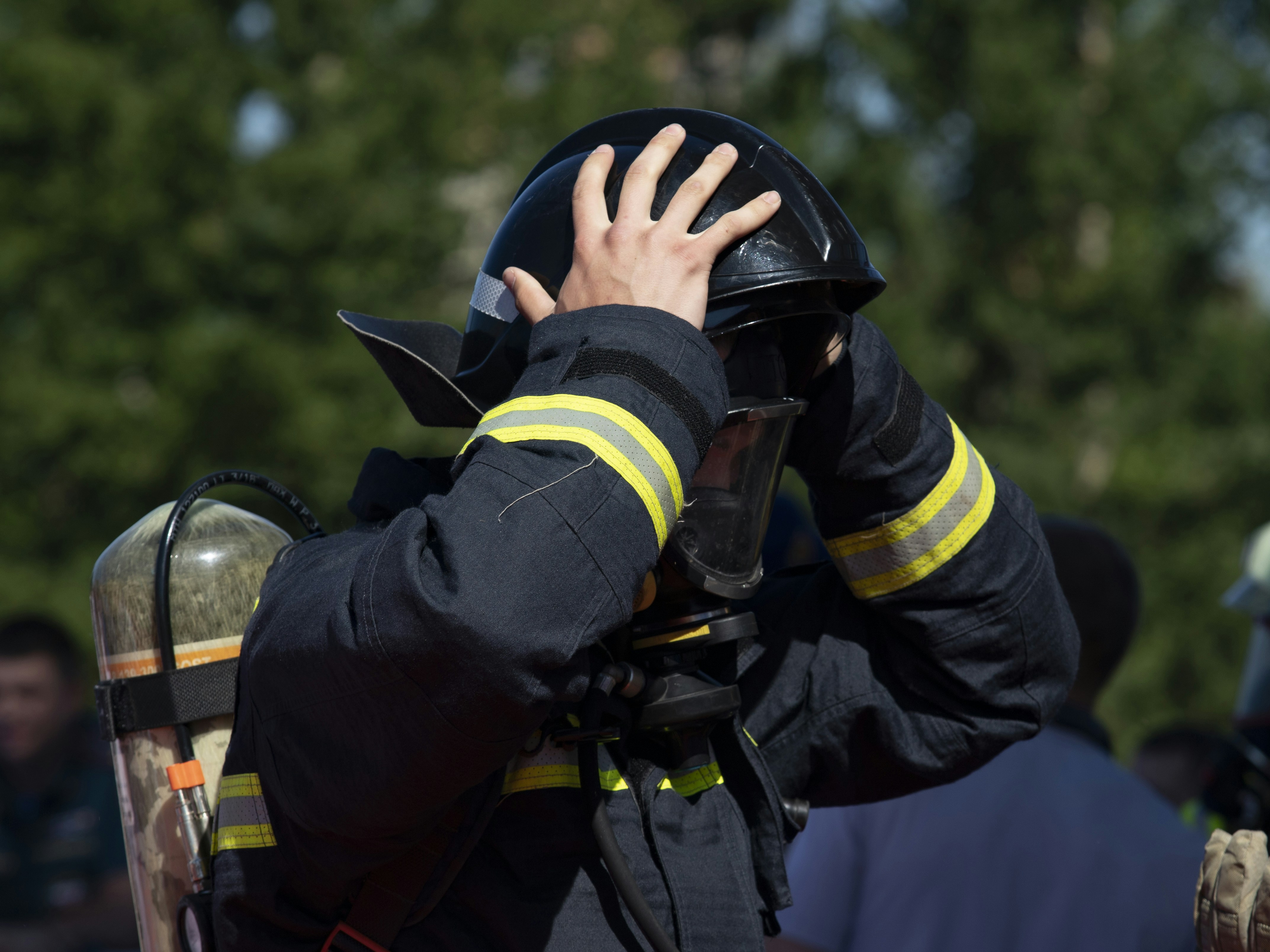 Heroic Gasp: A Firefighter Adjusts Gear Under Pressure