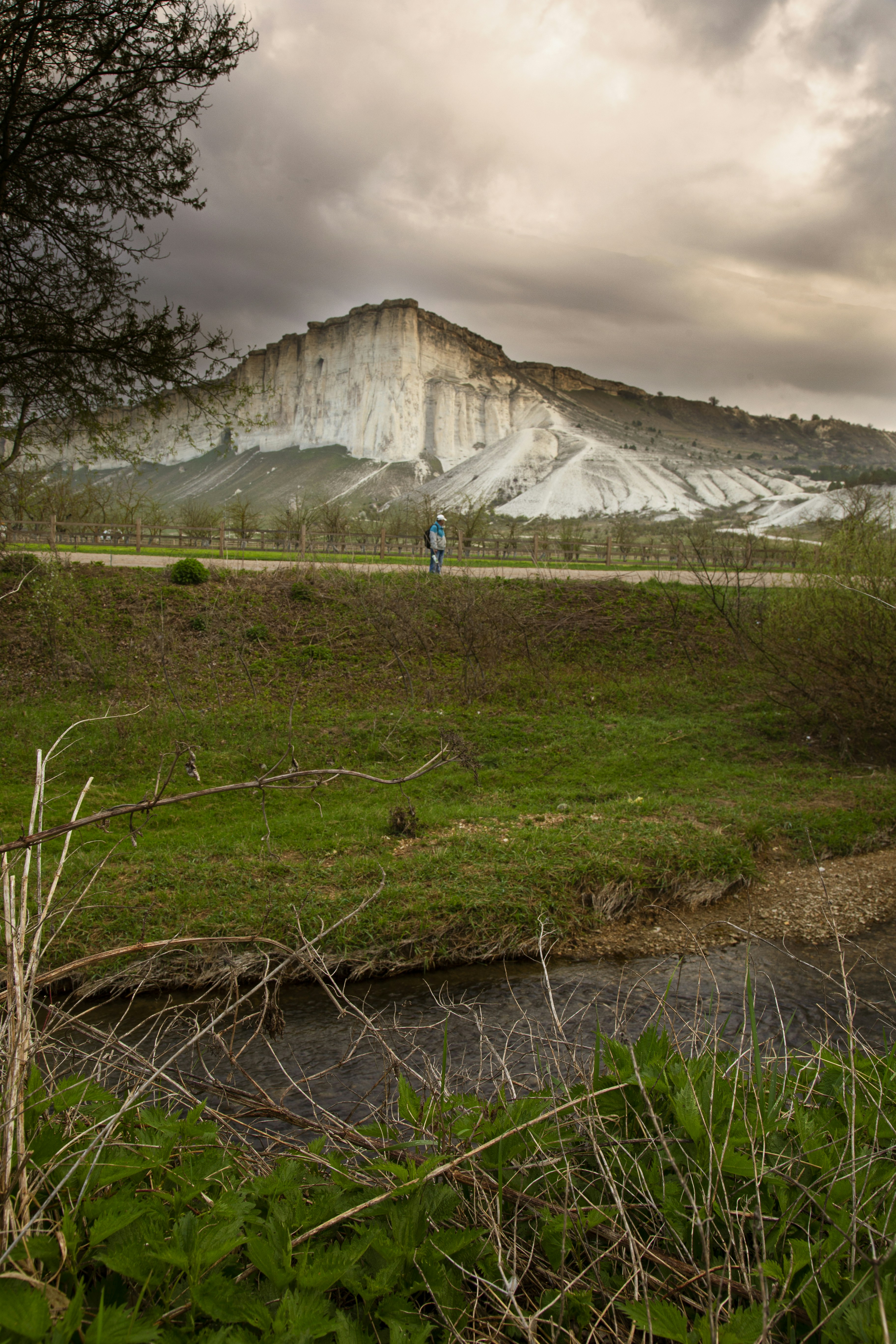  solitary walker before chalky cliffs beneath a brooding sky