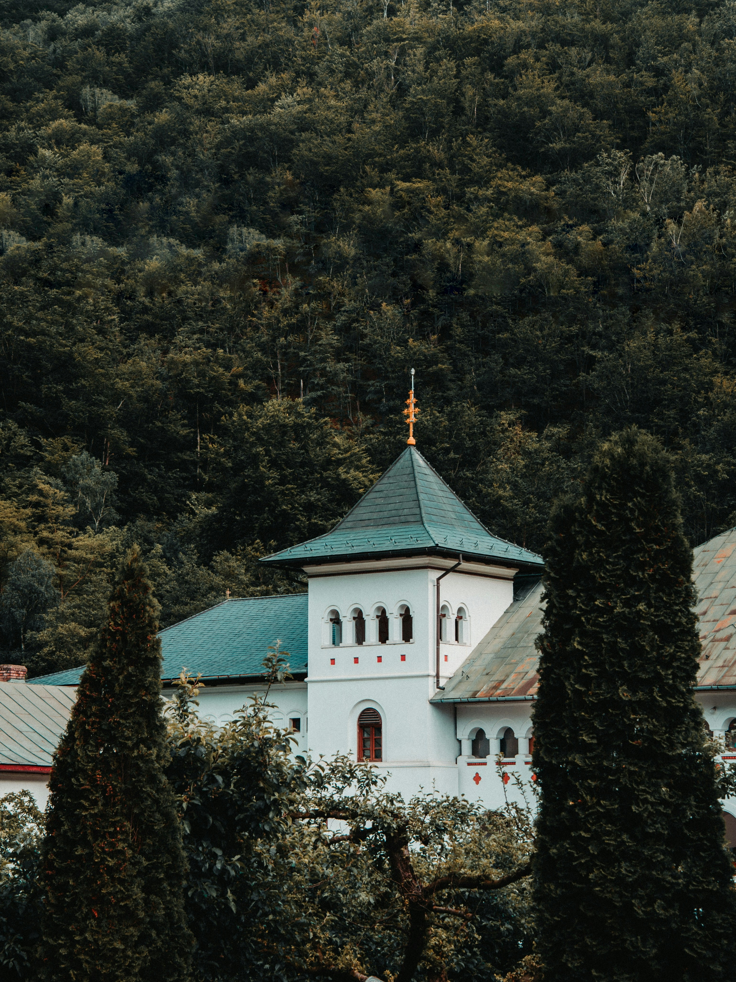 Pastoral Fortress: White Structure Amid Forested Hills