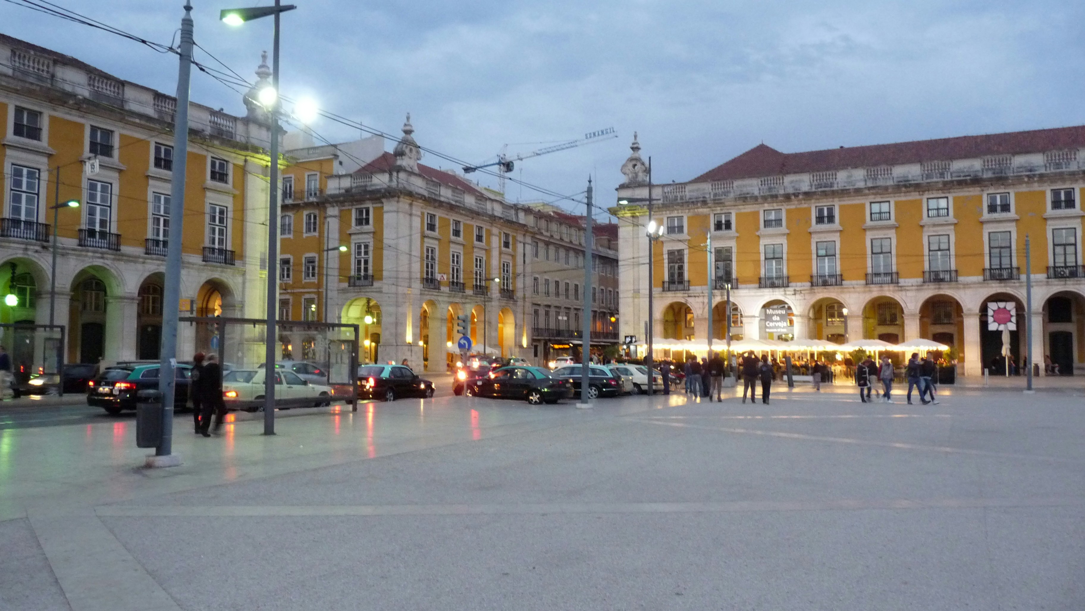 Golden Arcades at Dusk: People and Cars Cloak the Piazza