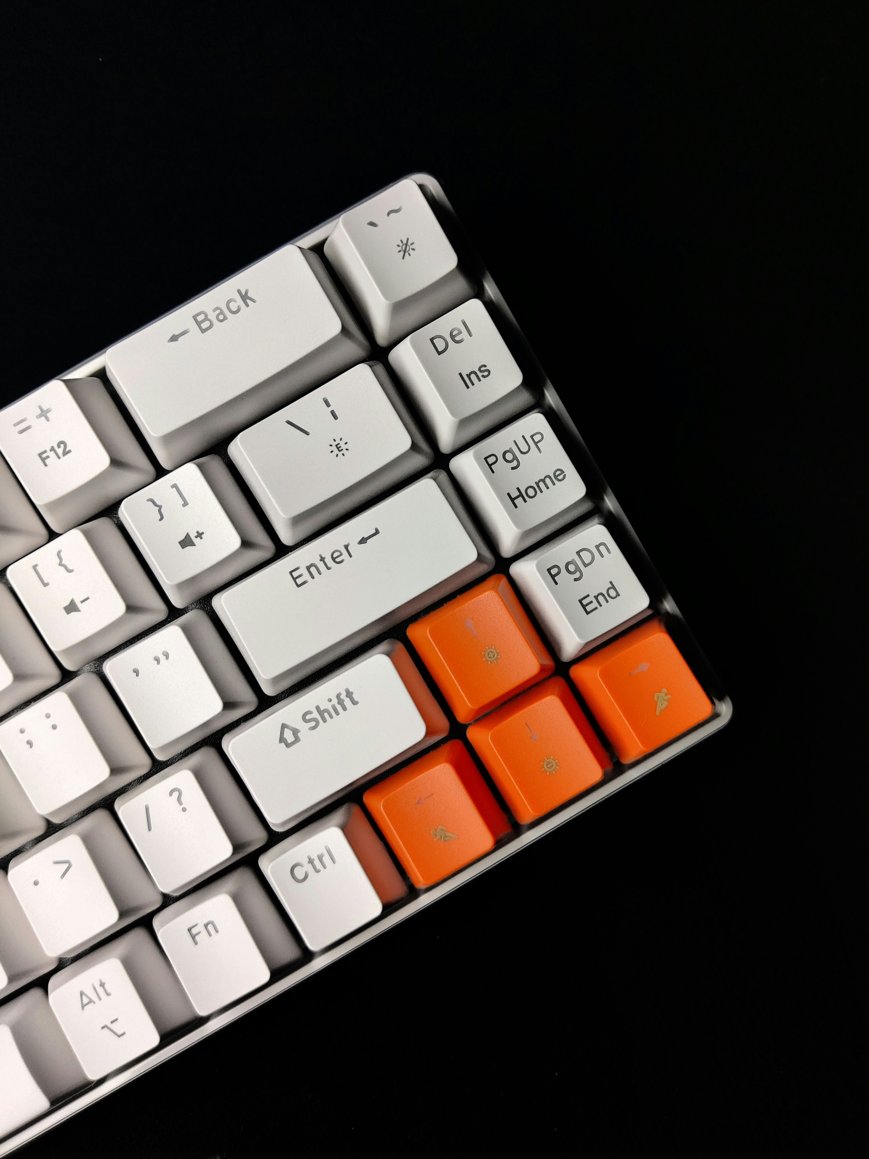 Orange-tipped keyboard cluster resting at the edge of a black void