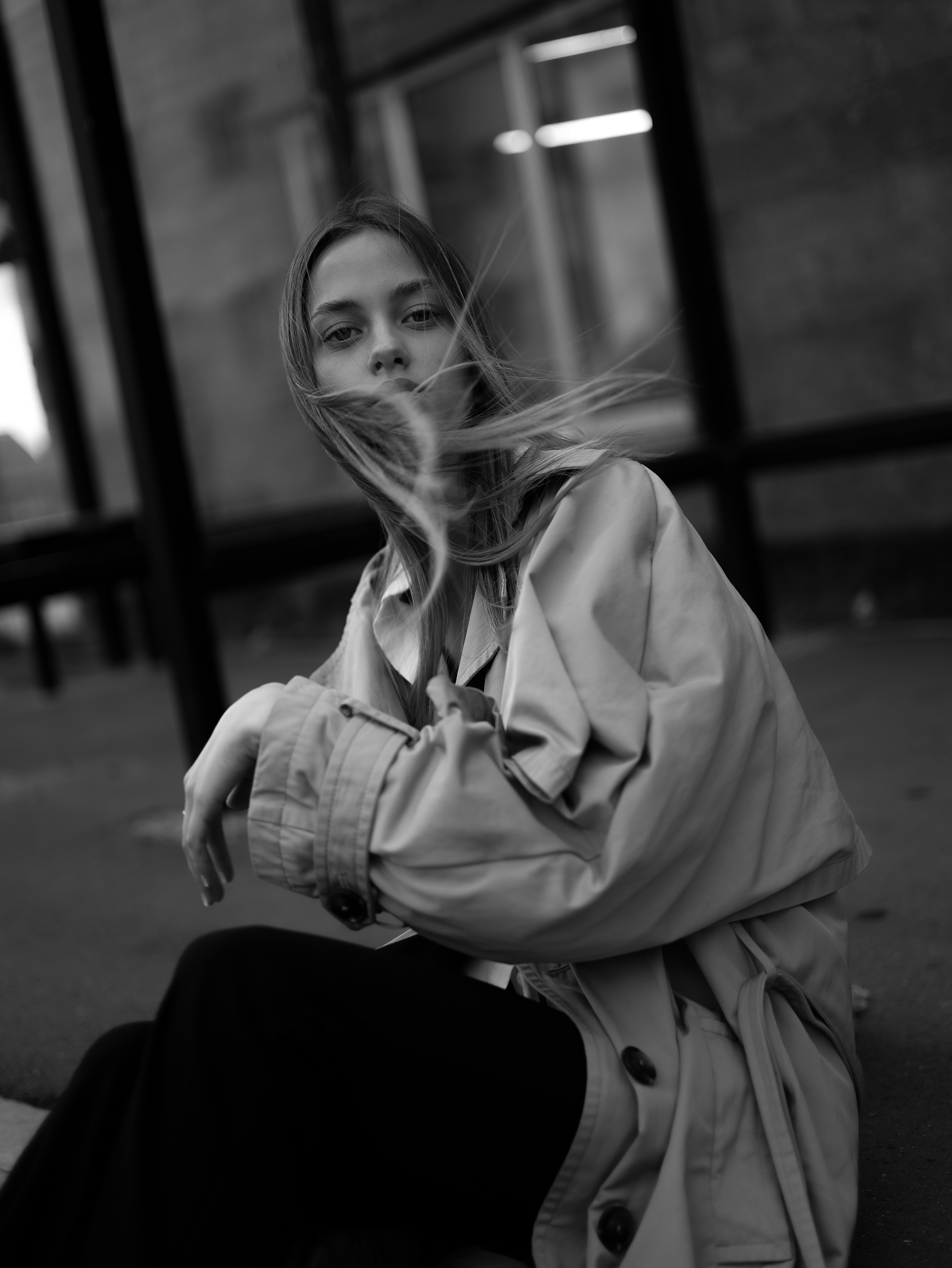 Portrait in Motion: Wind-swept Gaze Beneath Urban Glass