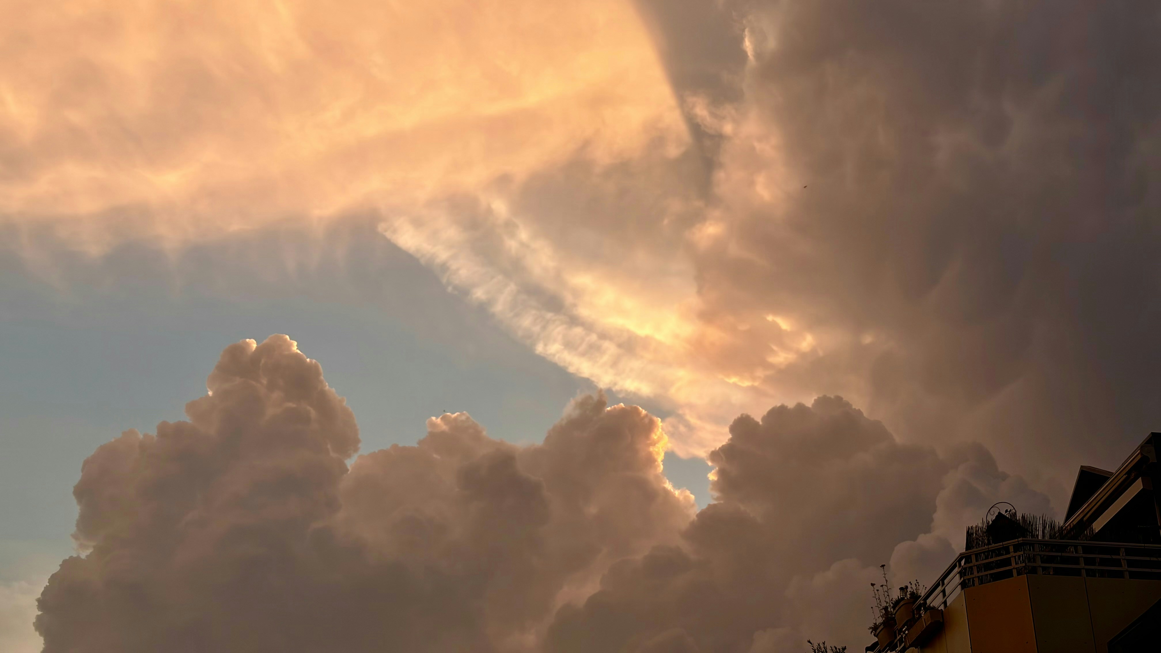 Golden-Edge Clouds Over a Rooftop Horizon