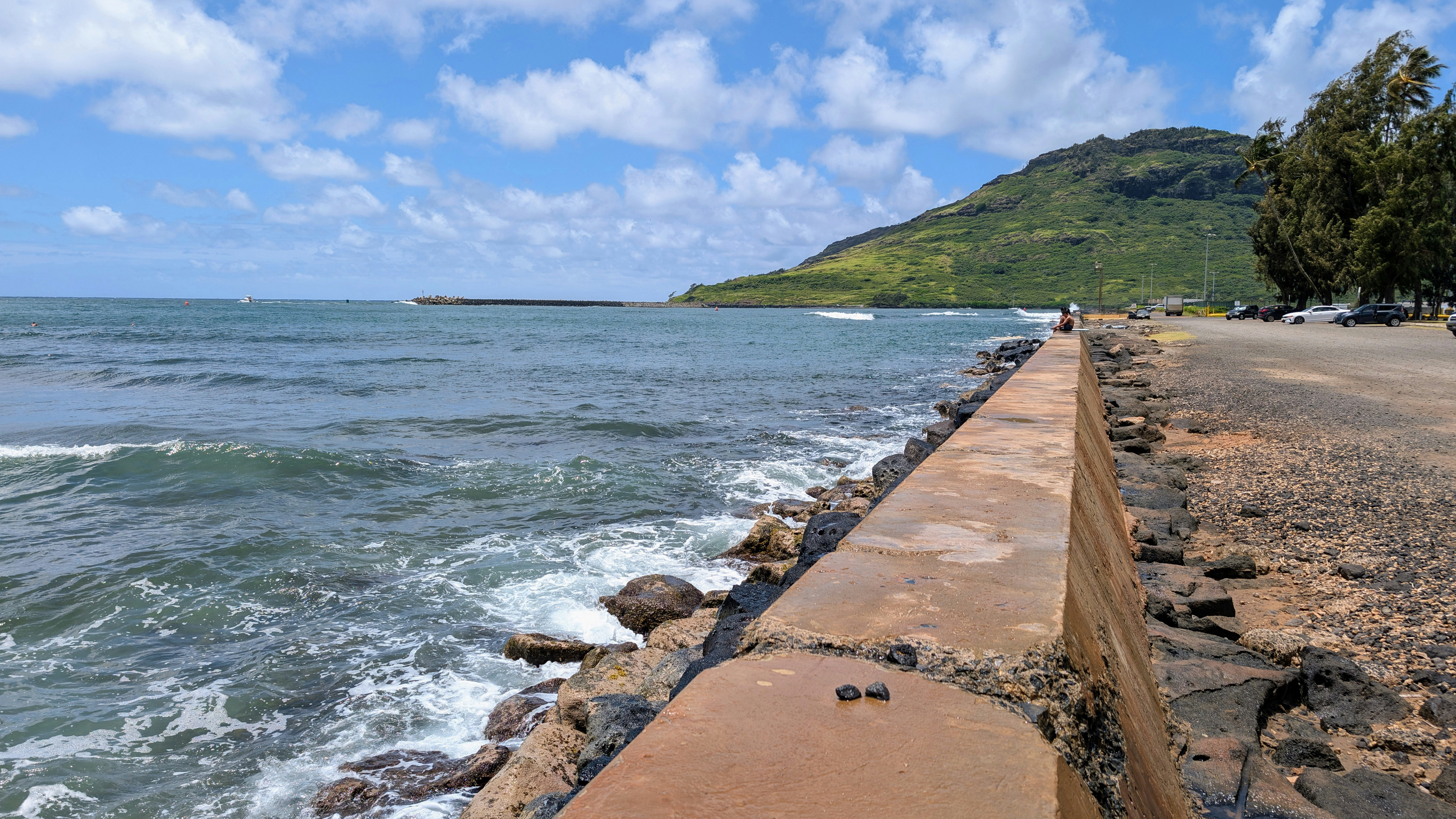 Coastal Promenade: A Rusted Breakwater Marks the Path by the Emerald Hills