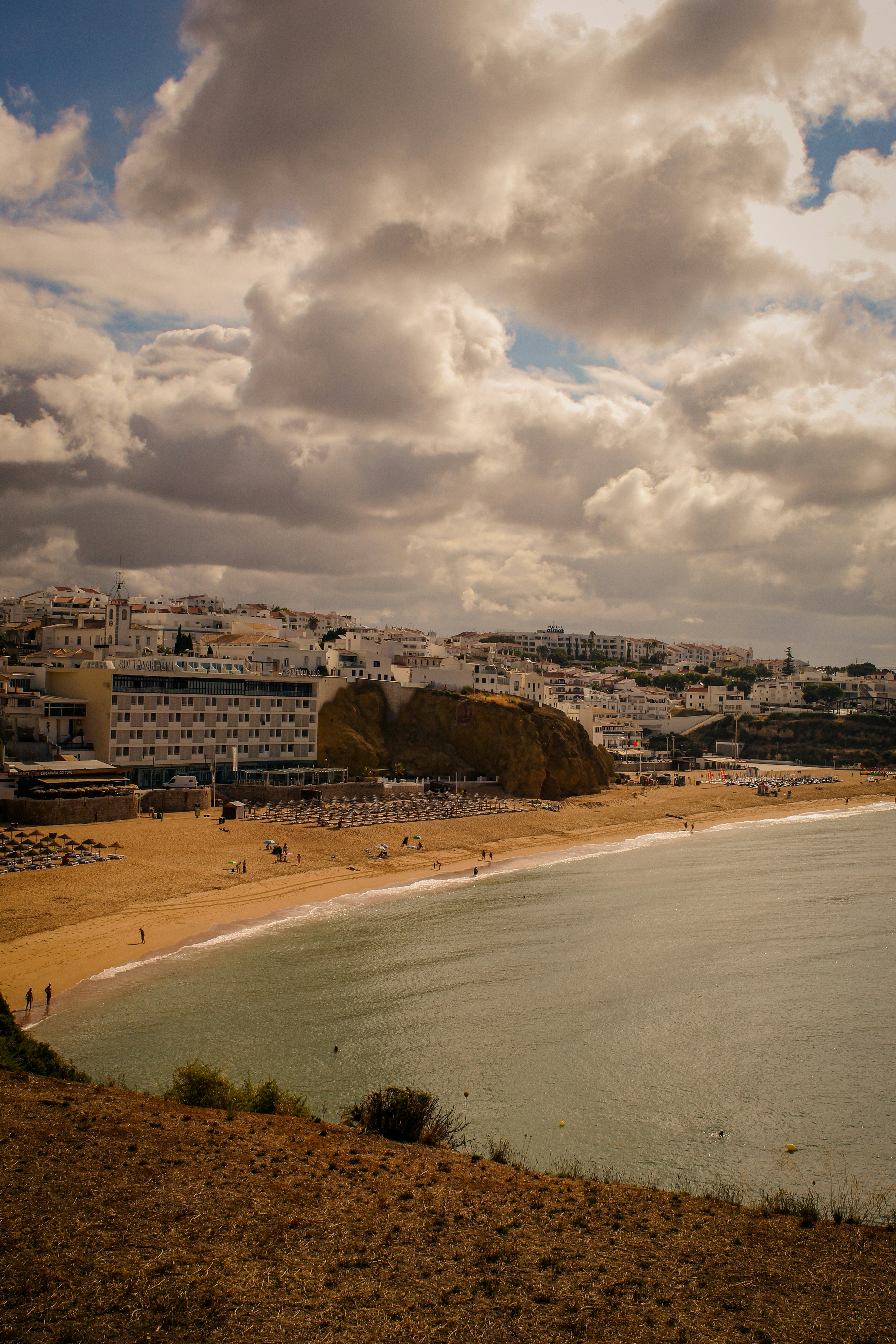 Coastal Town Reverie: Beachline Under Cloud-filled Skies