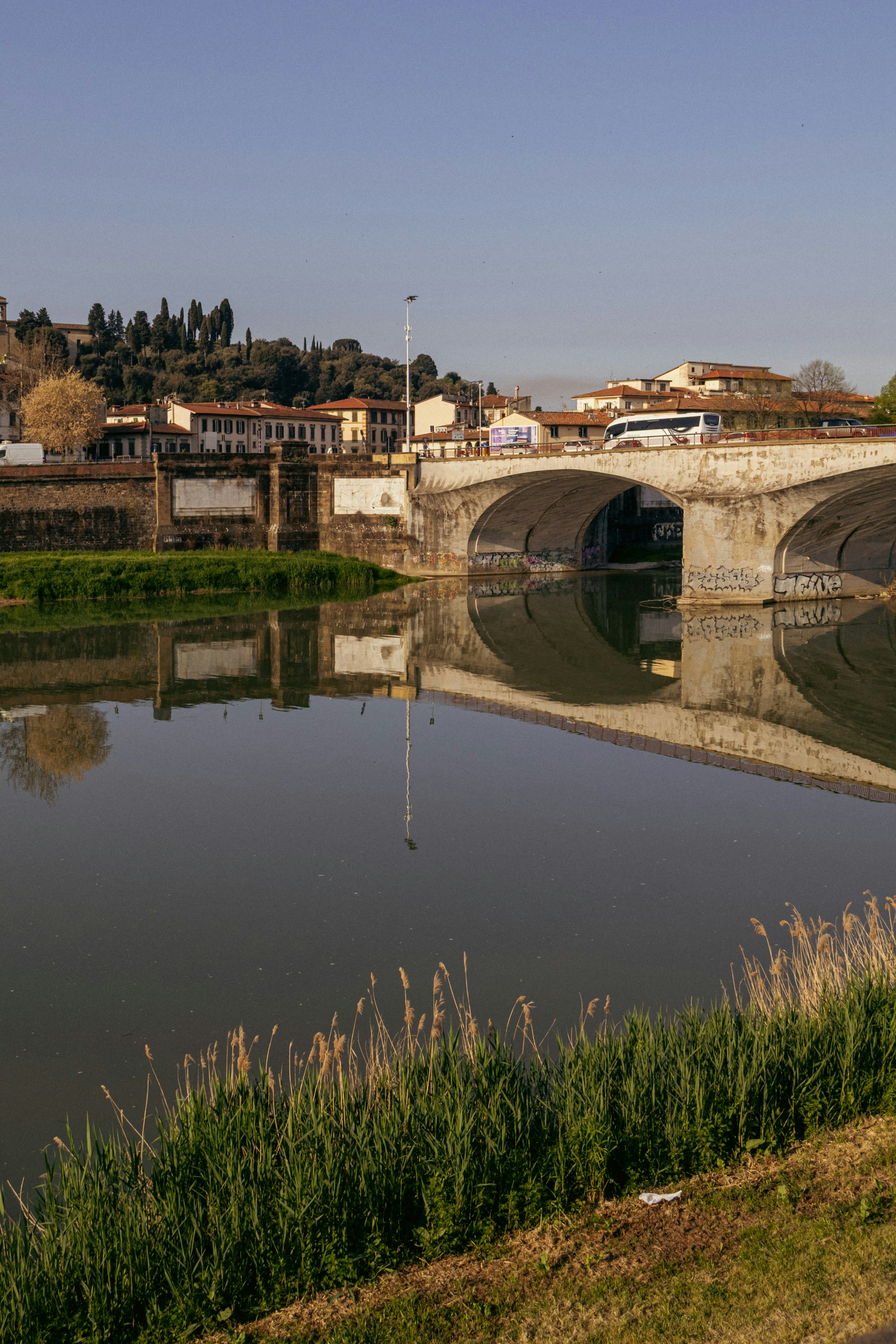 Stone Bridge Reaches Across a Calm River at Dusk