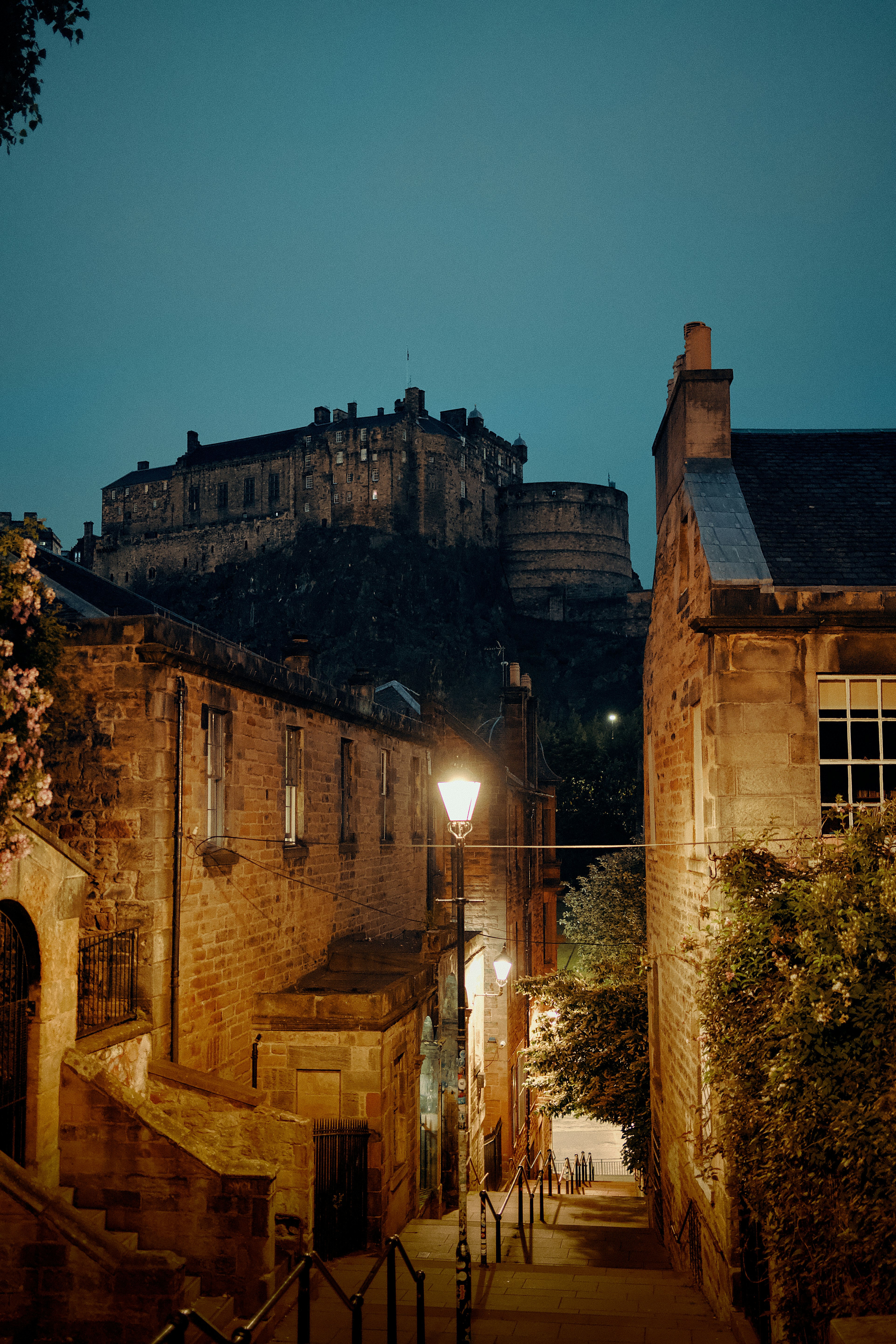 Evening Overlook: Castle Silhouette Beyond Stone Alley