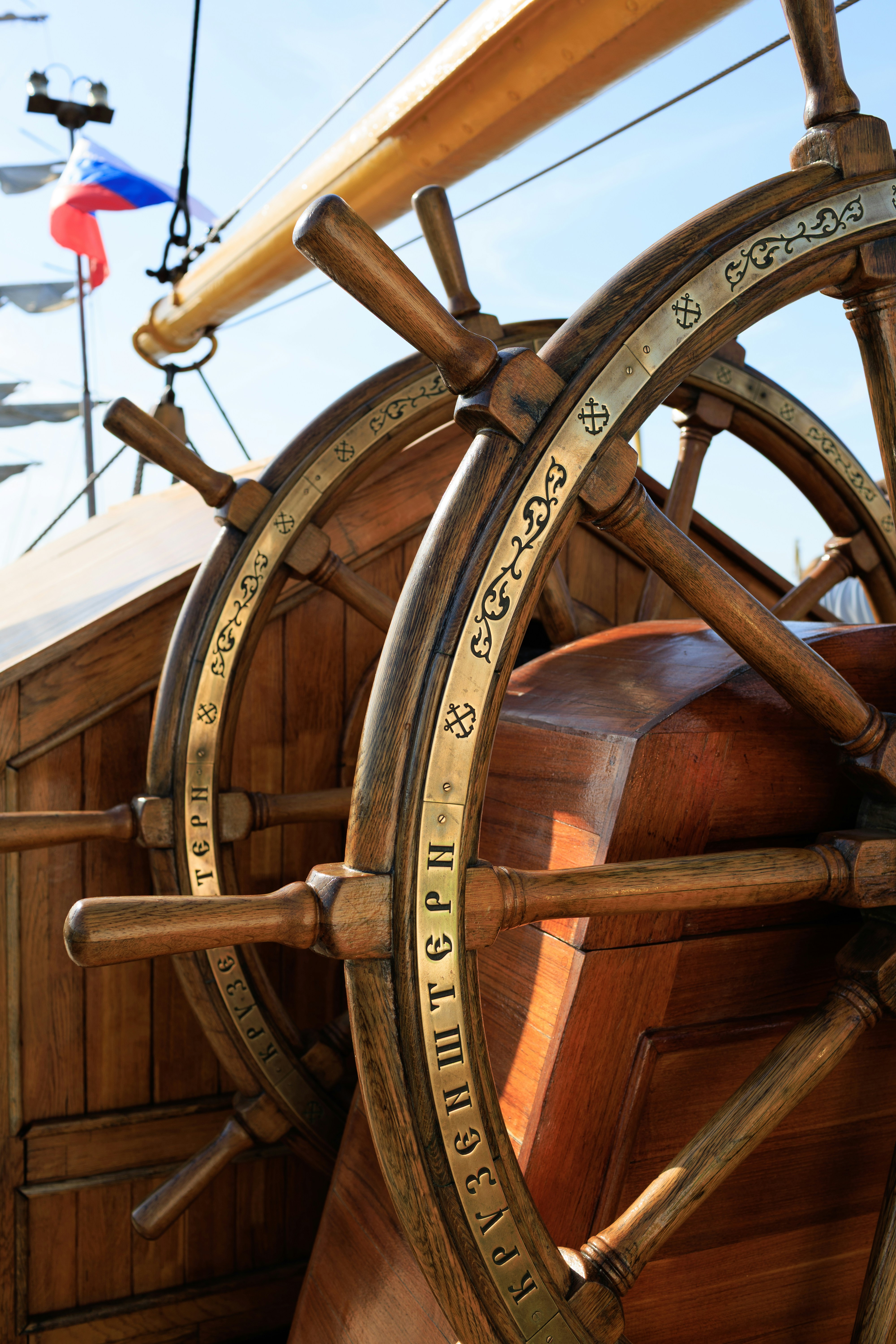 Vintage helm in focus: brass-rimmed wheel guiding the wooden deck
