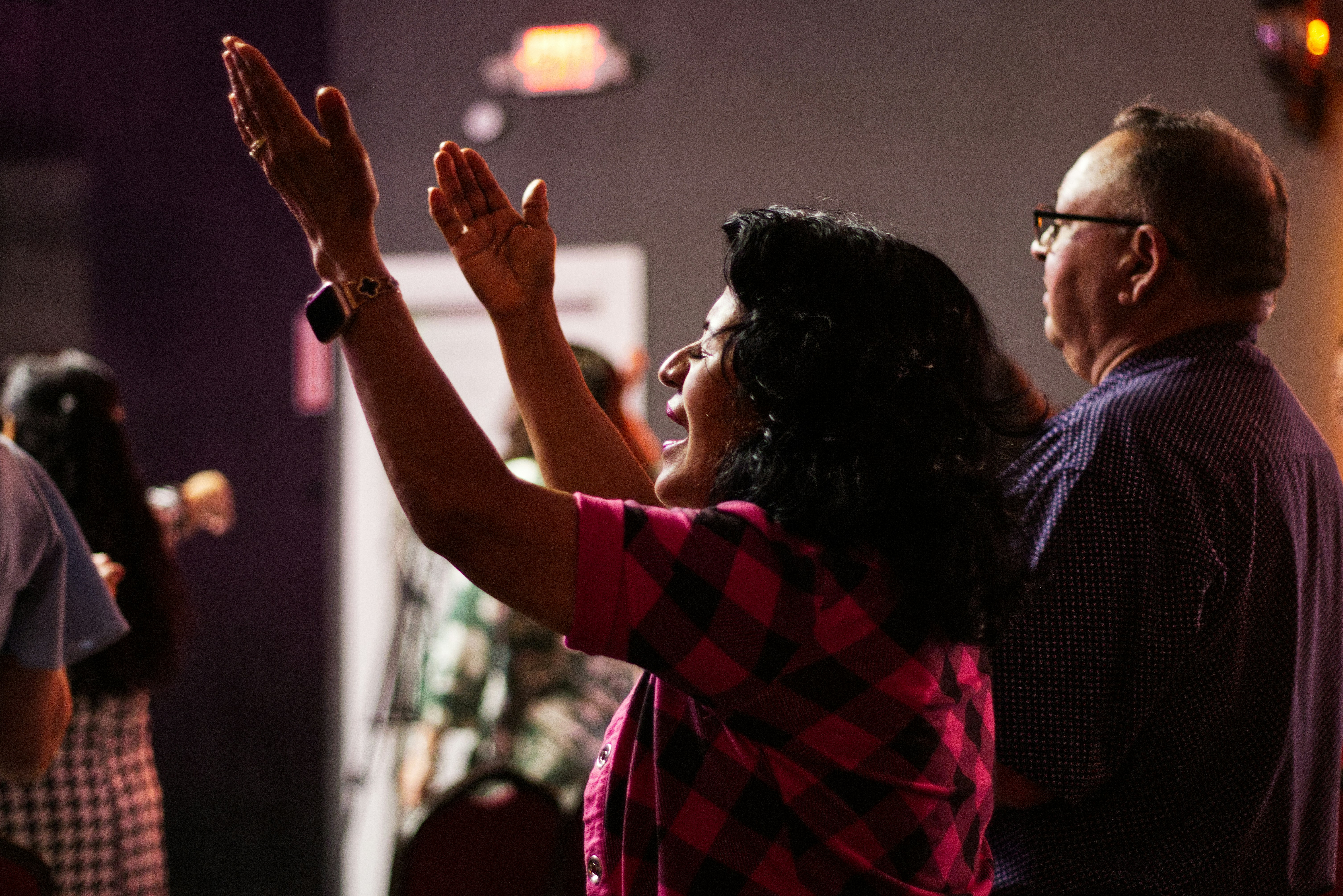 Hands Raised, Spotlighted Energy: A Crowd in Quiet Praise