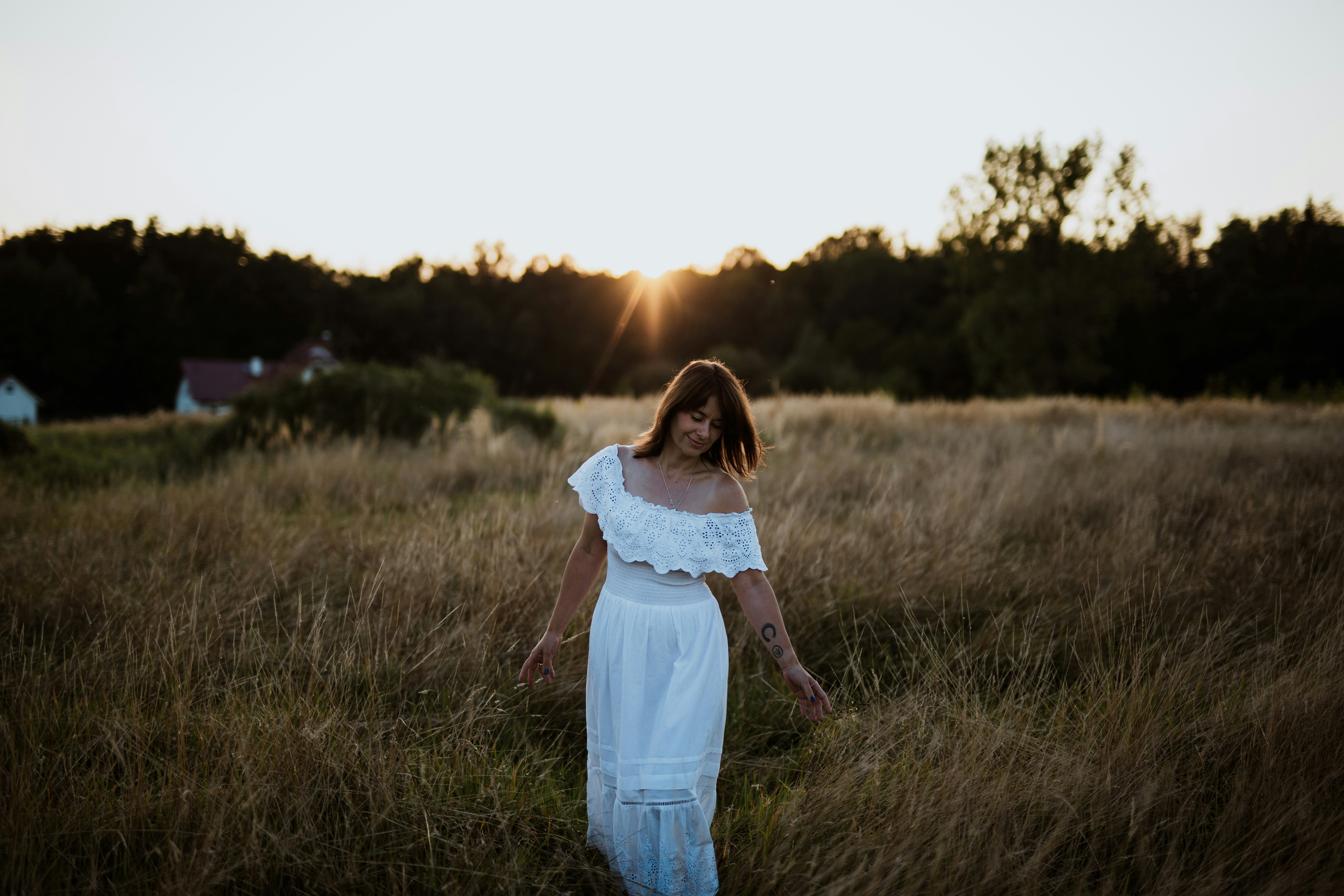 Field of Quiet White: A Woman in a Flowing Dress at Sunset