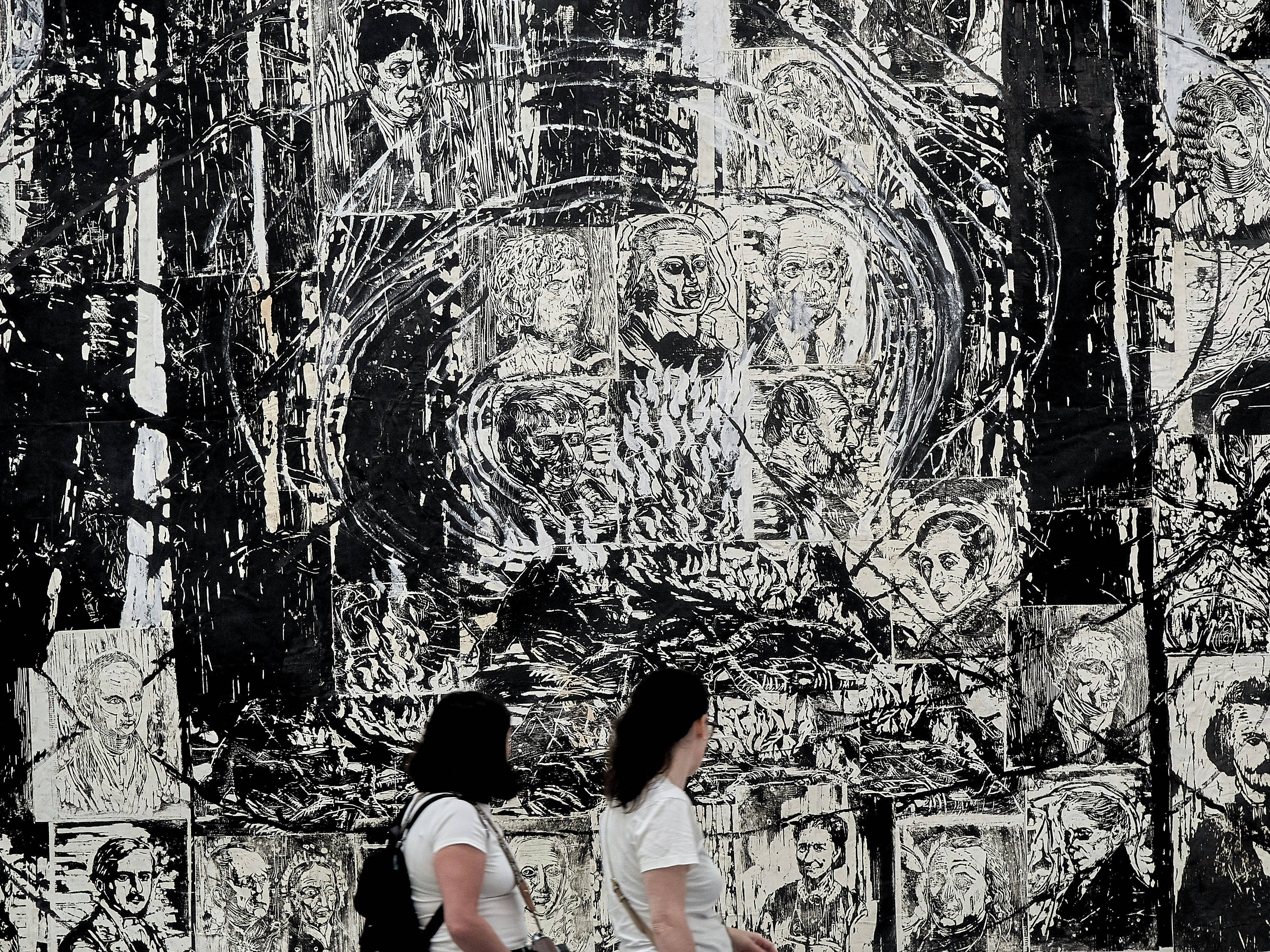 Echoes of Portraits: Two Tourists Amid a Collage of Faces