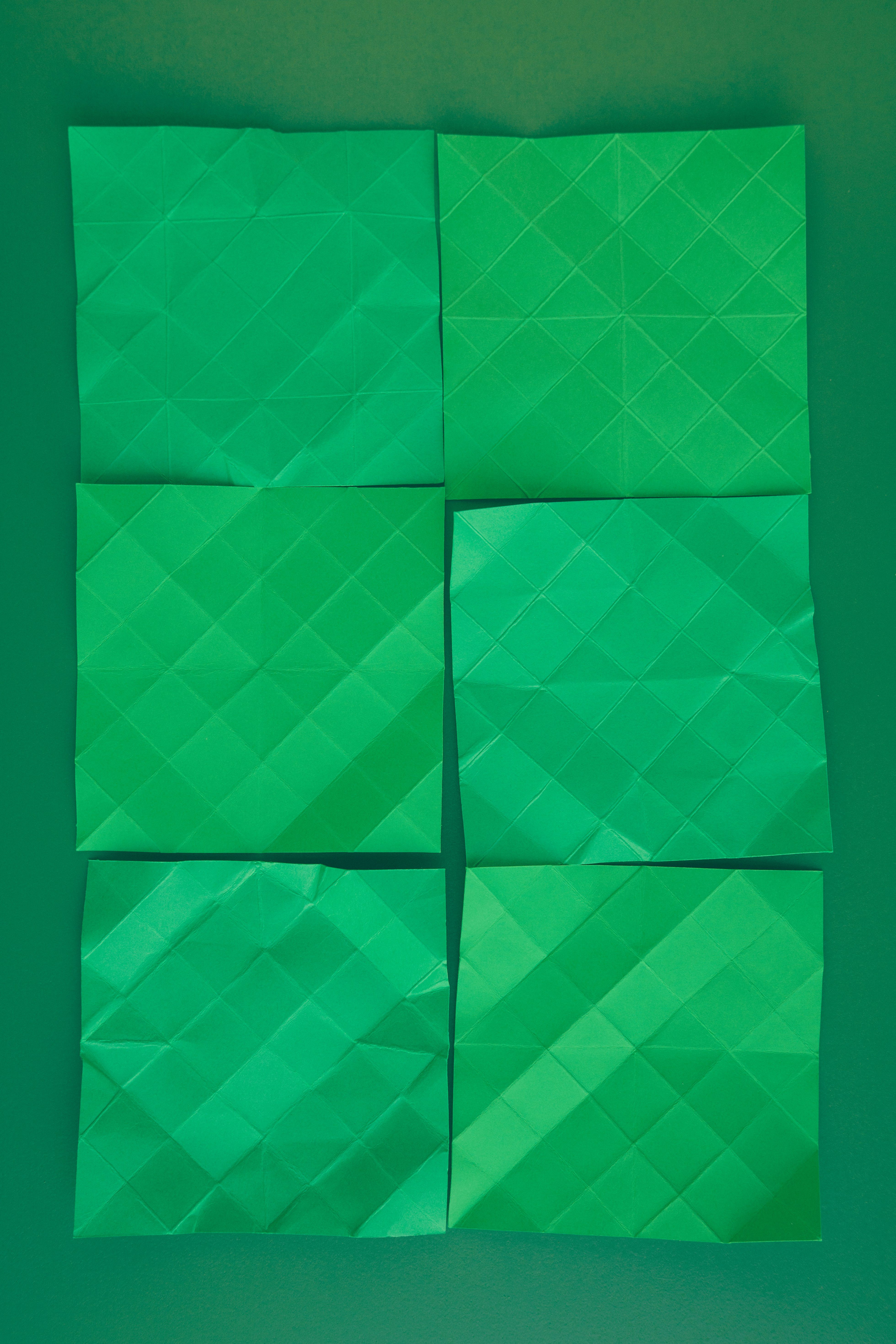 Six Emerald-Grid Notes: Geometric Green Origami on a Solid Backdrop