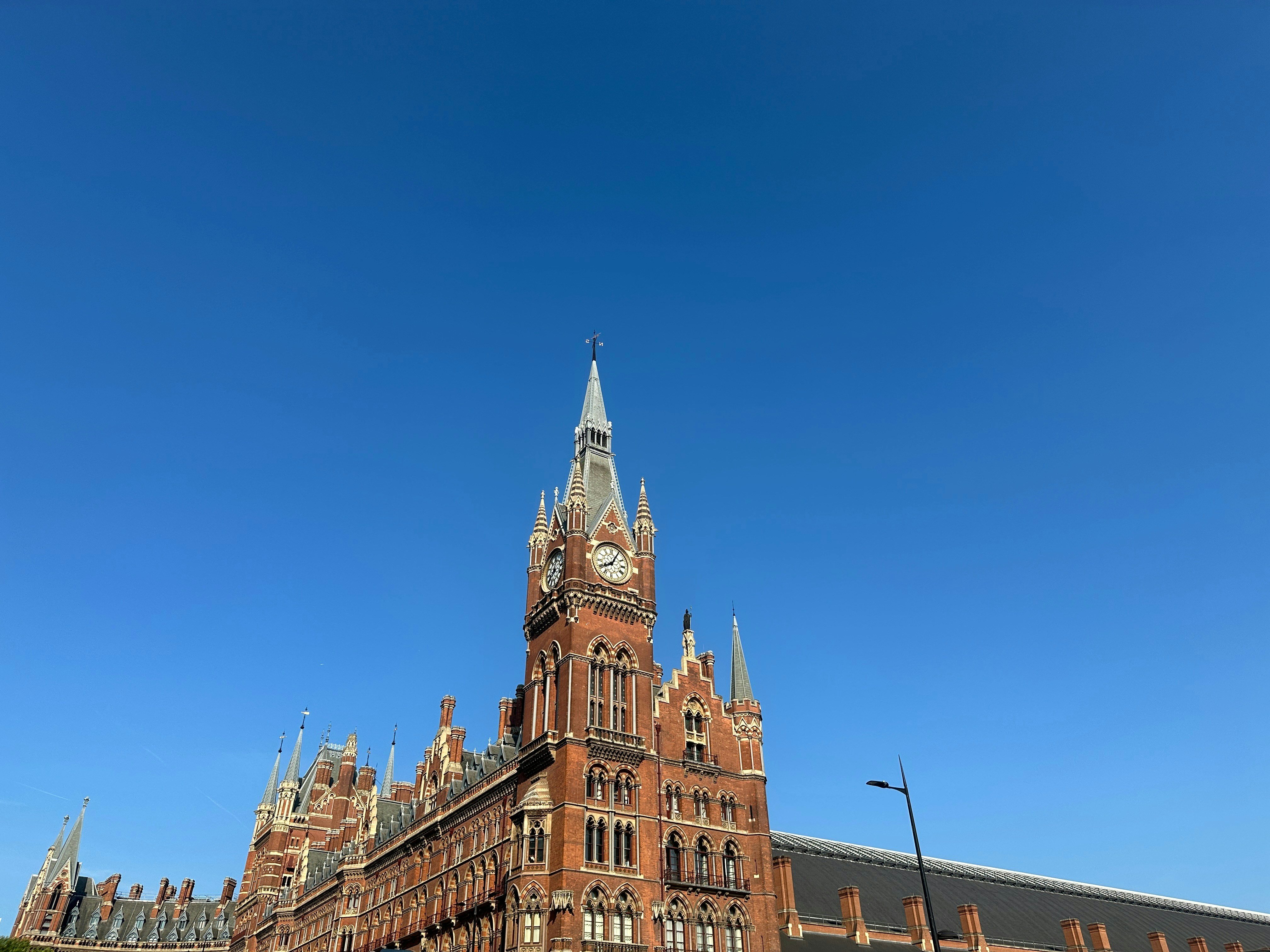 Gothic Clocktower Rising Over Brick Facade Against a Cerulean Sky