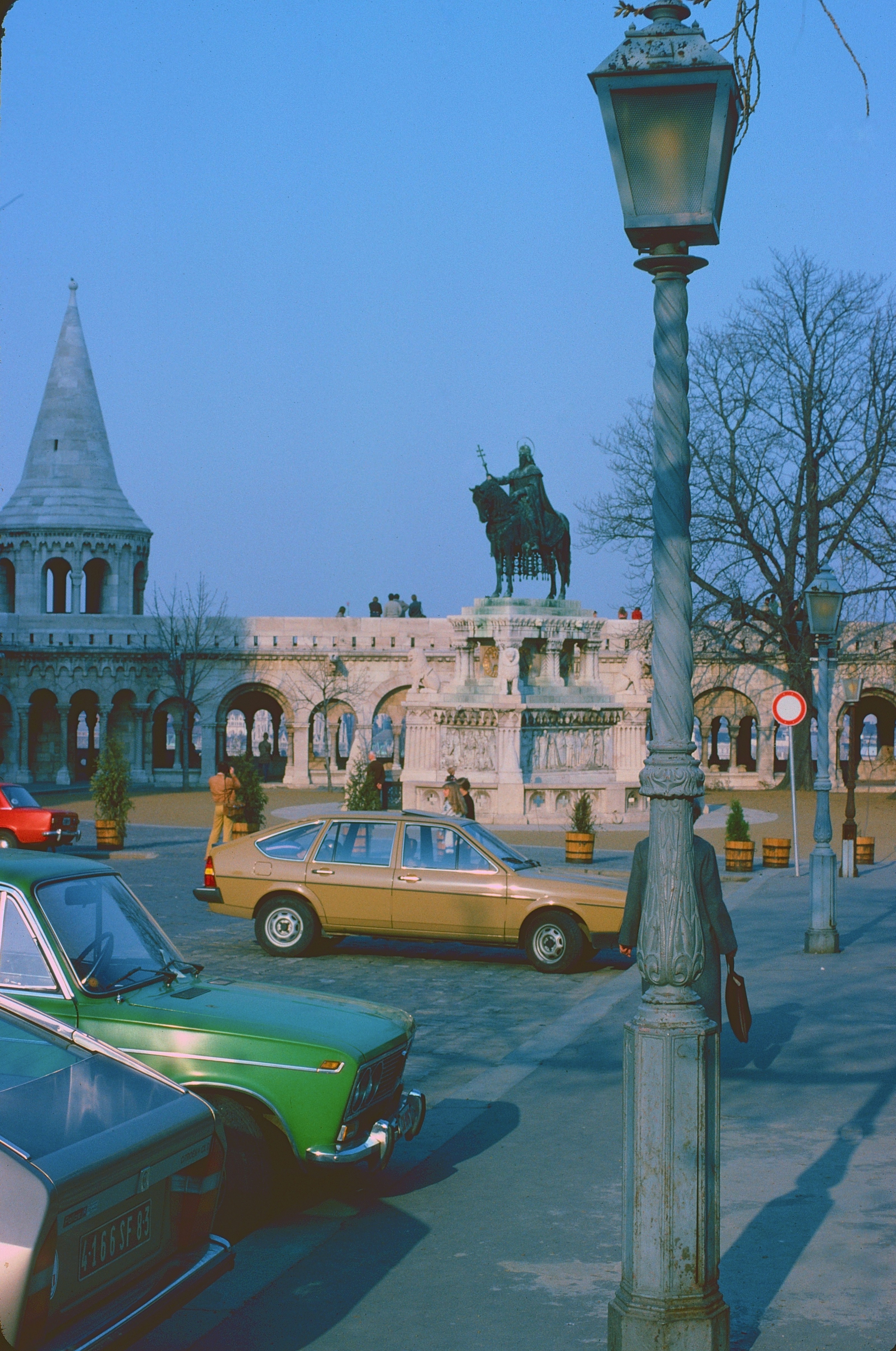 Pastel City Square: Historic Sculpture, Vintage Cars, and a Twilight Streetlamp