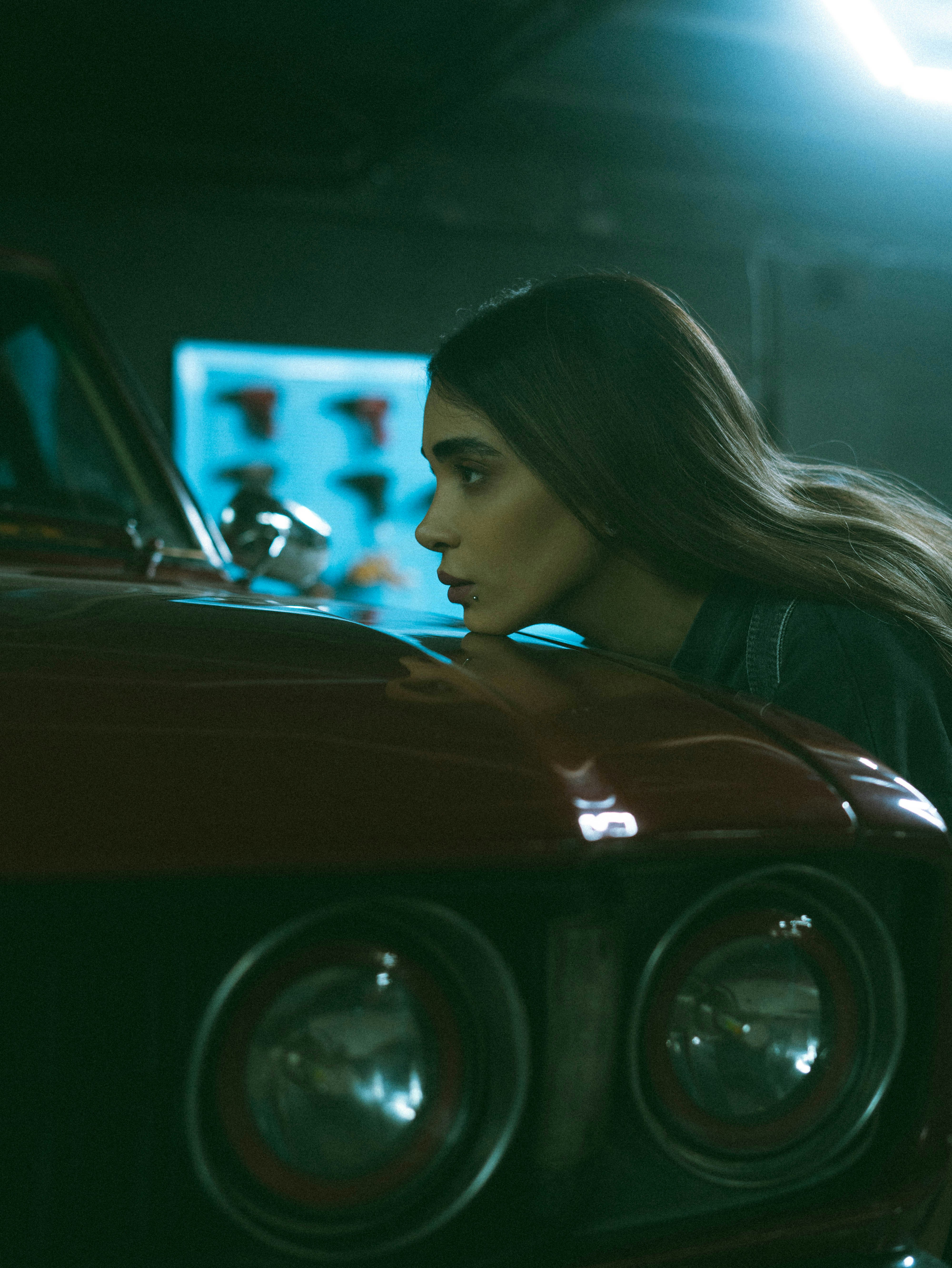 Eyes on the Car Hood: A Quiet Moment in Neon Steel