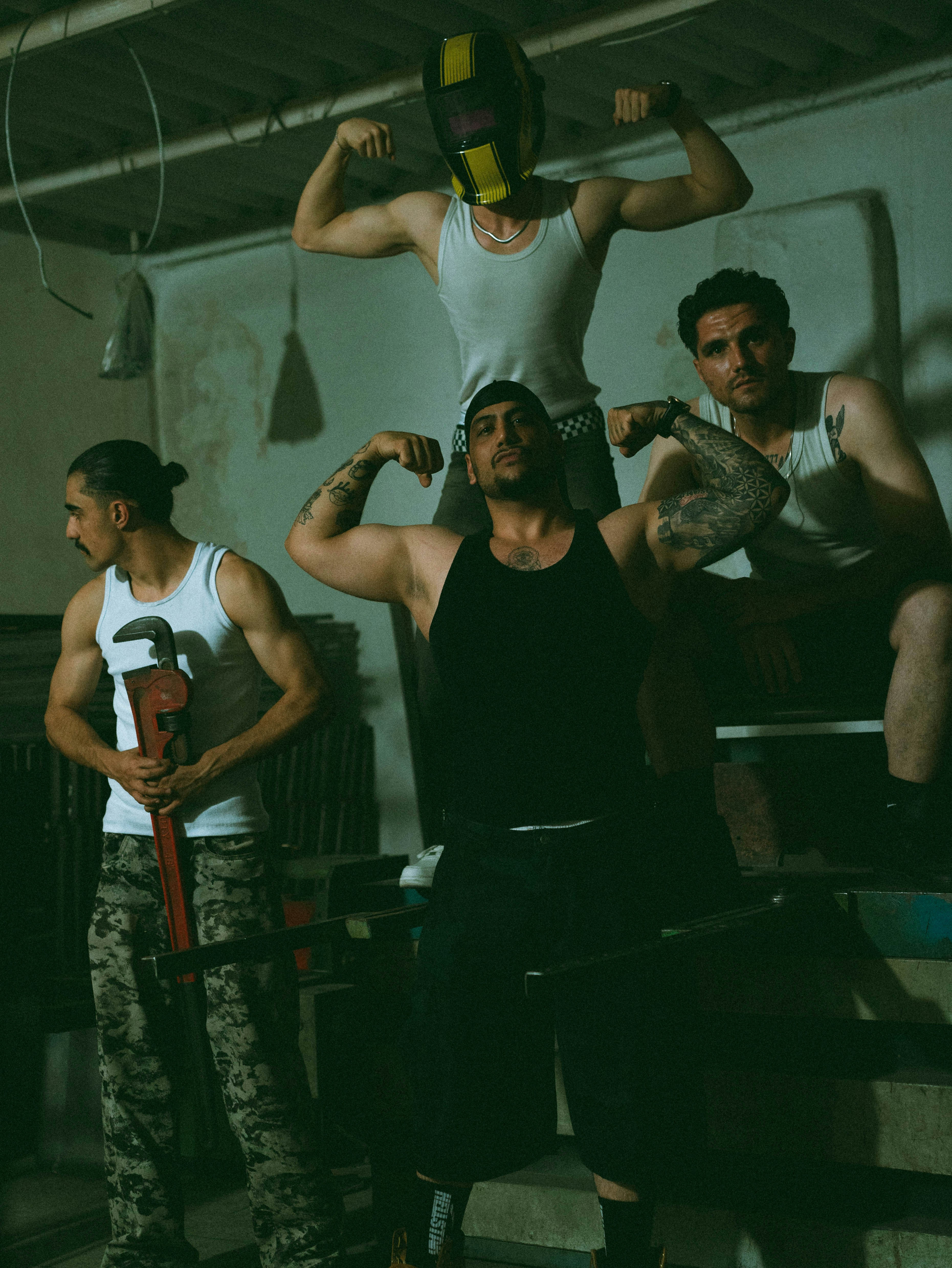 Group of Urban Muscles: Defiant Poses in a Dim Workshop