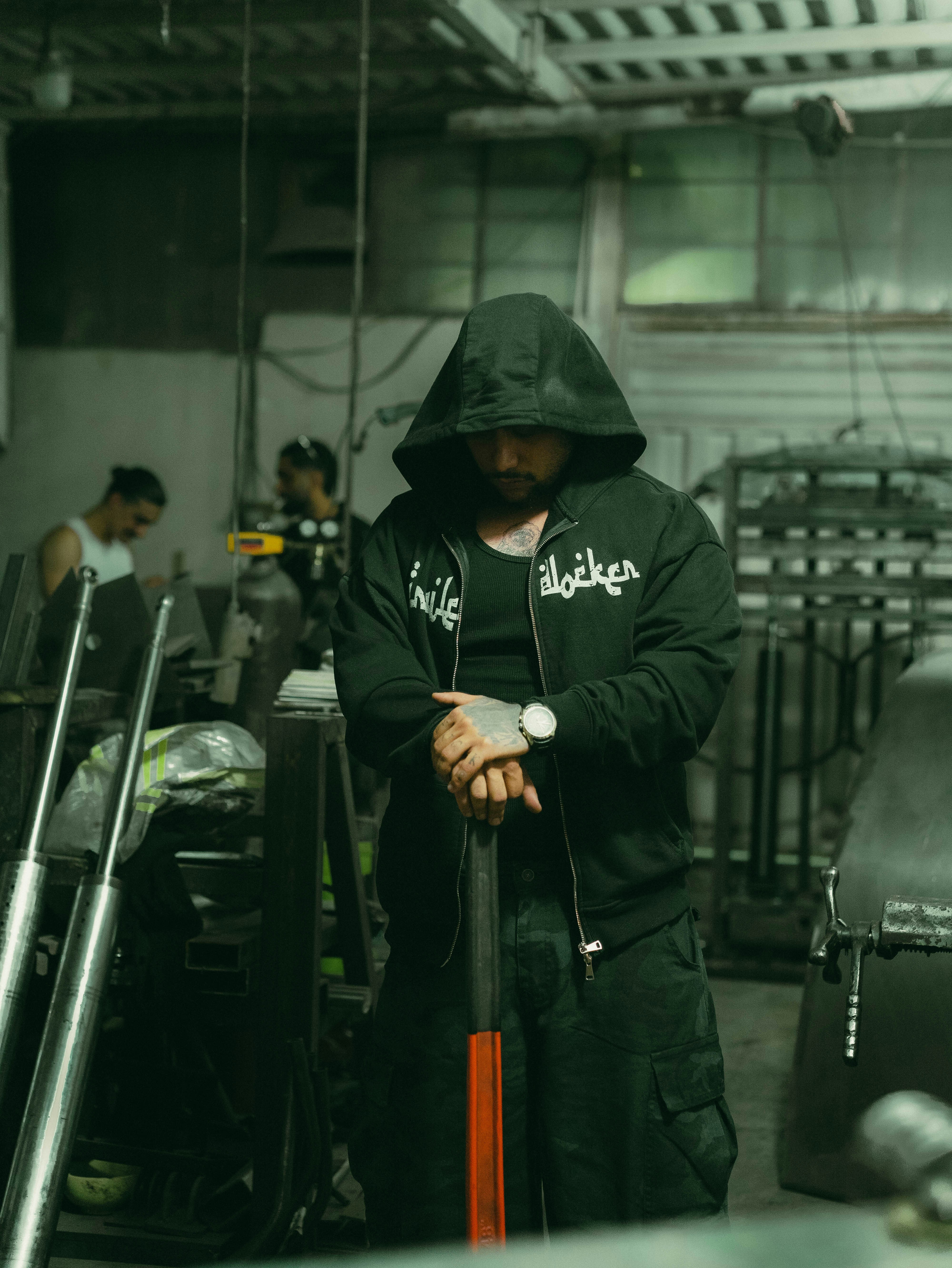 The Quiet Mechanic: A Hooded Figure in a Workshop